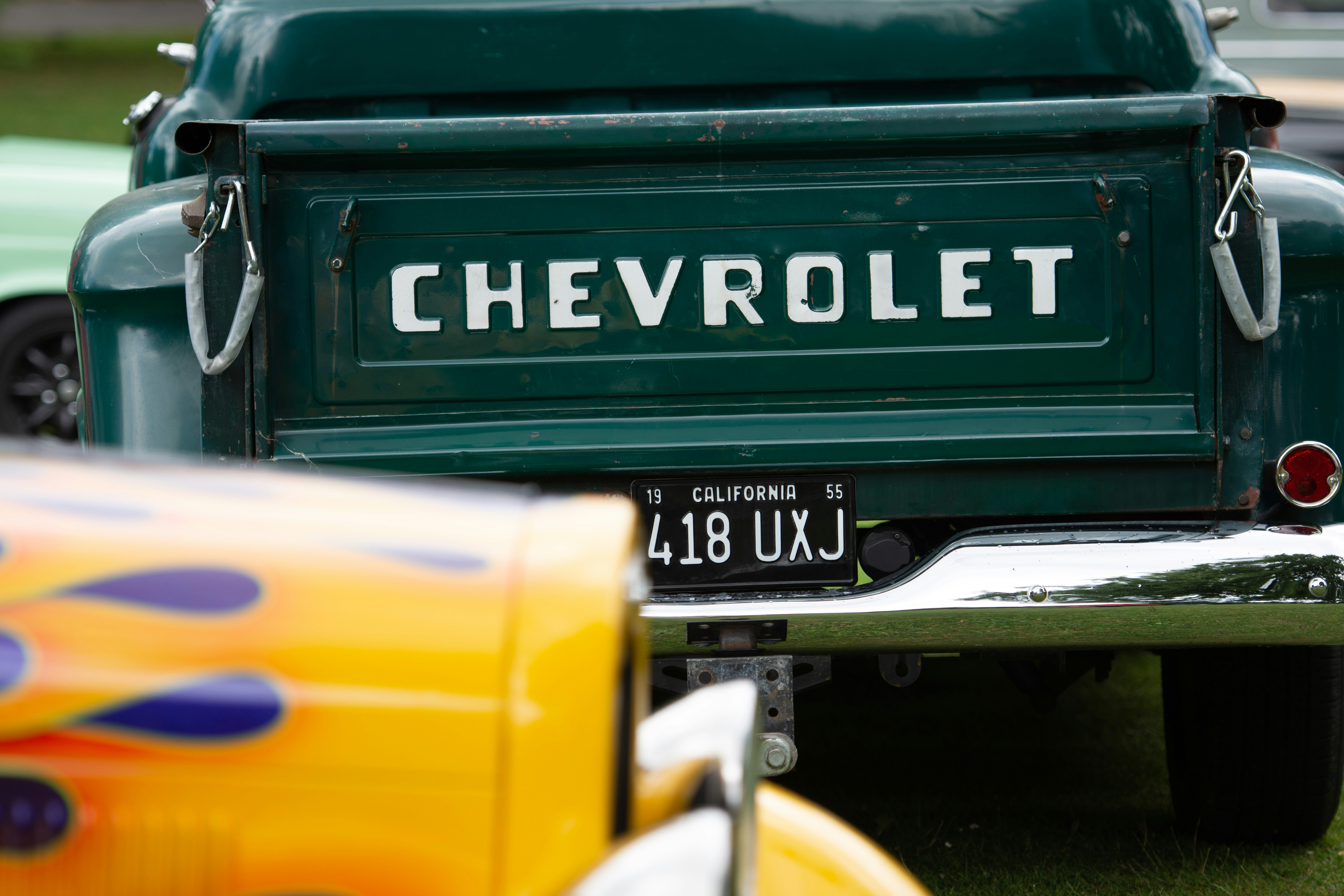a green truck with a yellow object in front of it