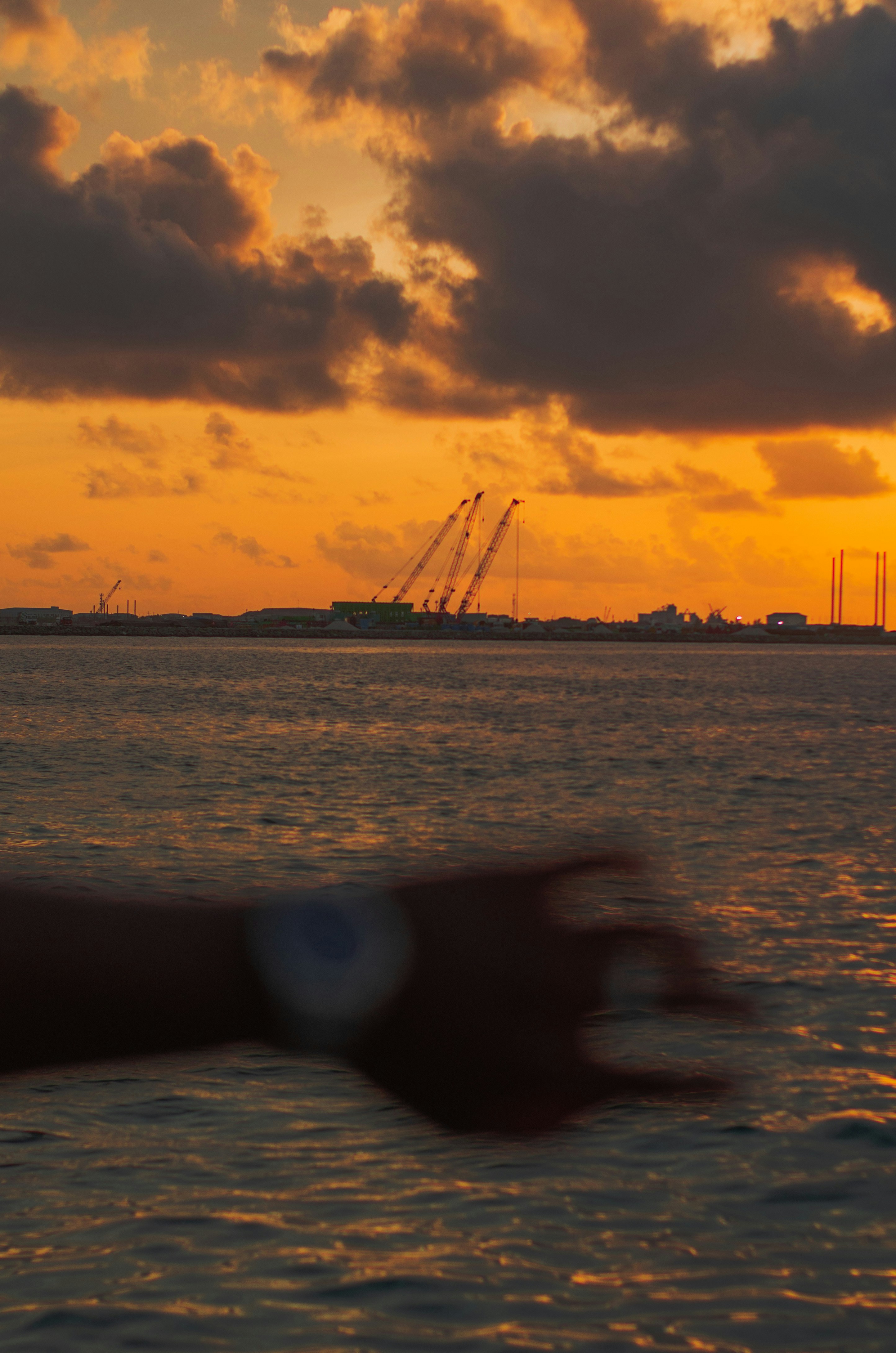 Sunset Over the Port: Silhouette of Cranes and a Fading Foreground Reach