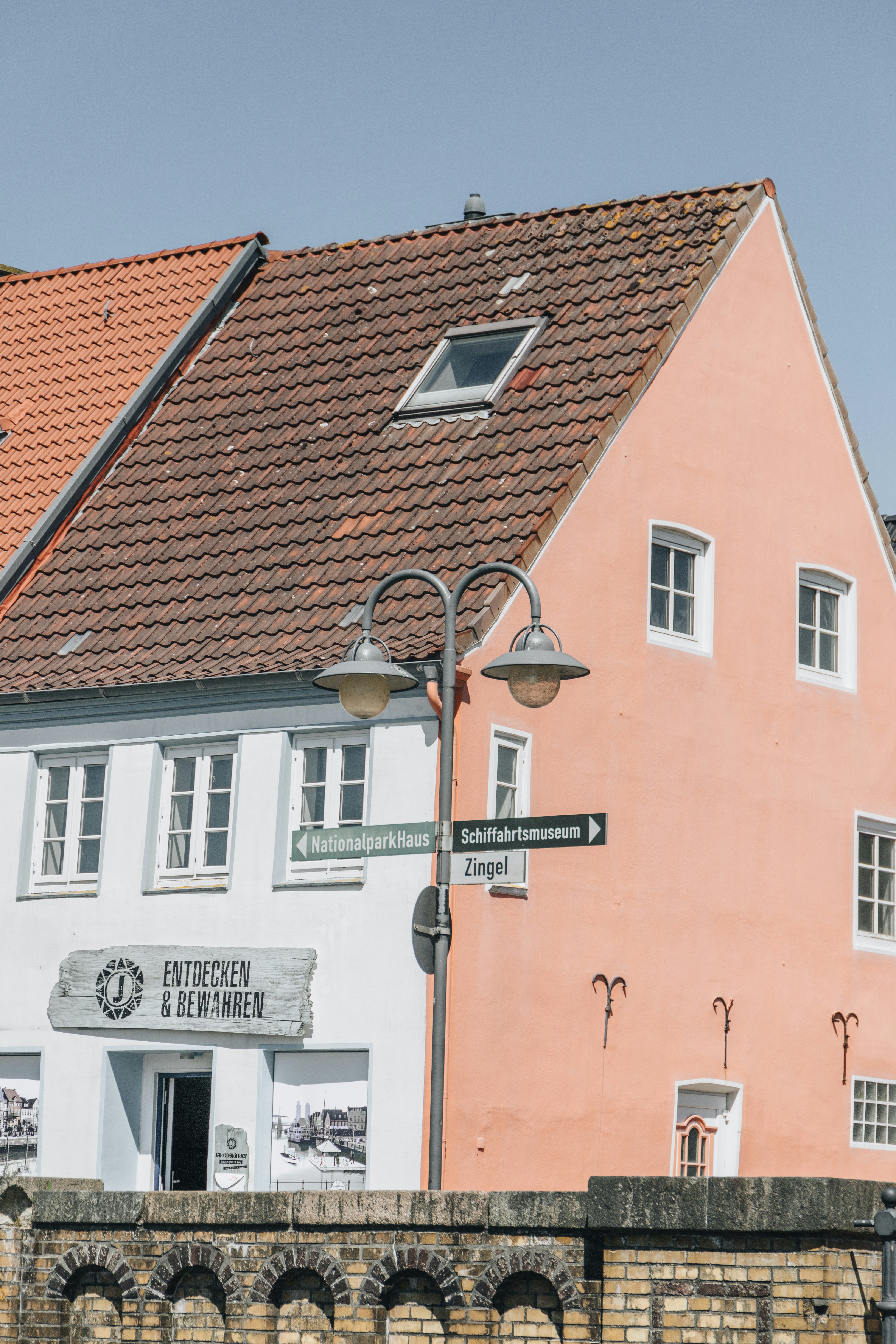 Pastel Facades and Signpost Stories on a Quiet Riverside Street