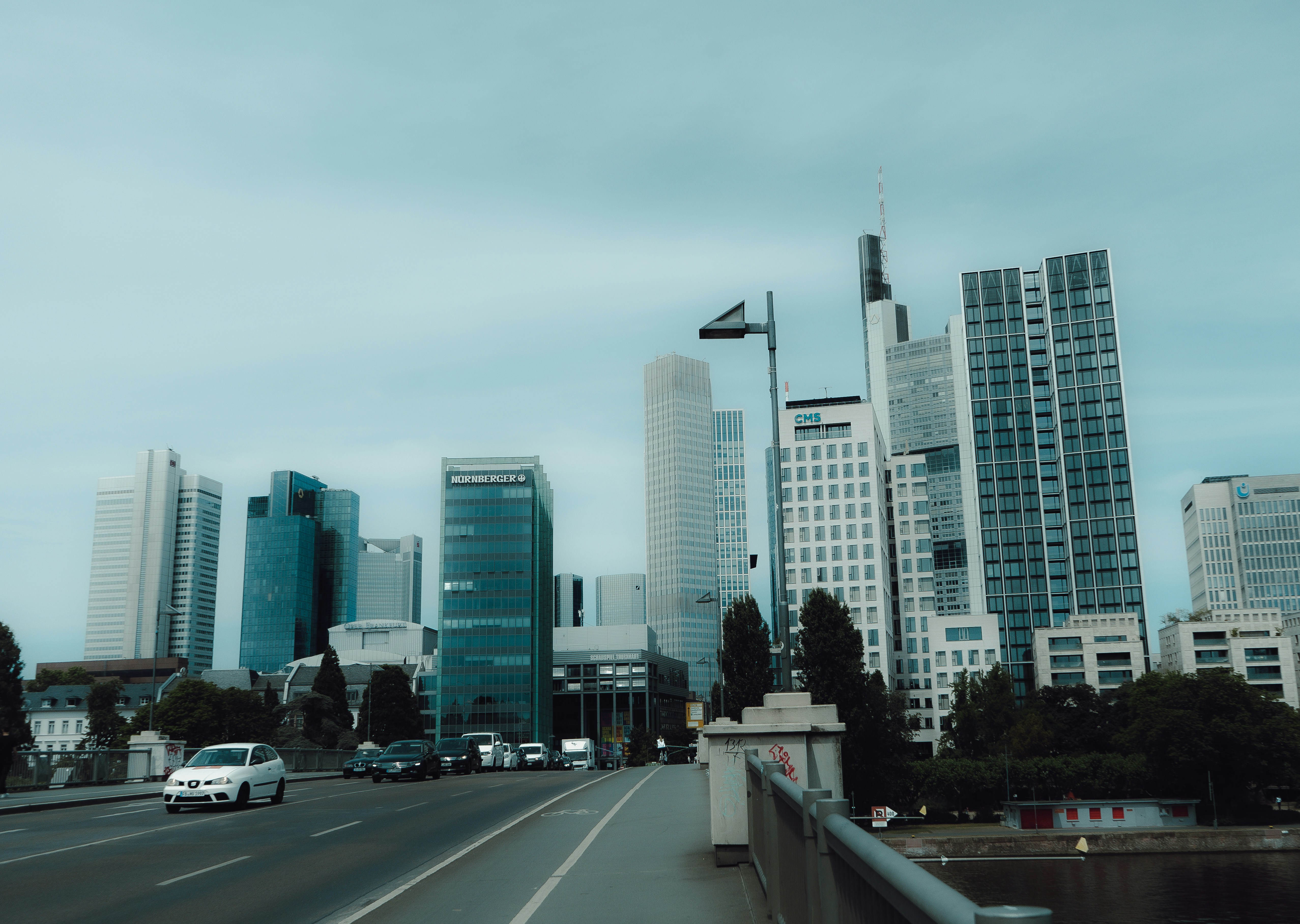 A bustling urban scene showcasing a skyline of contemporary skyscrapers under a moody sky. The image captures the dynamic essence of city life.