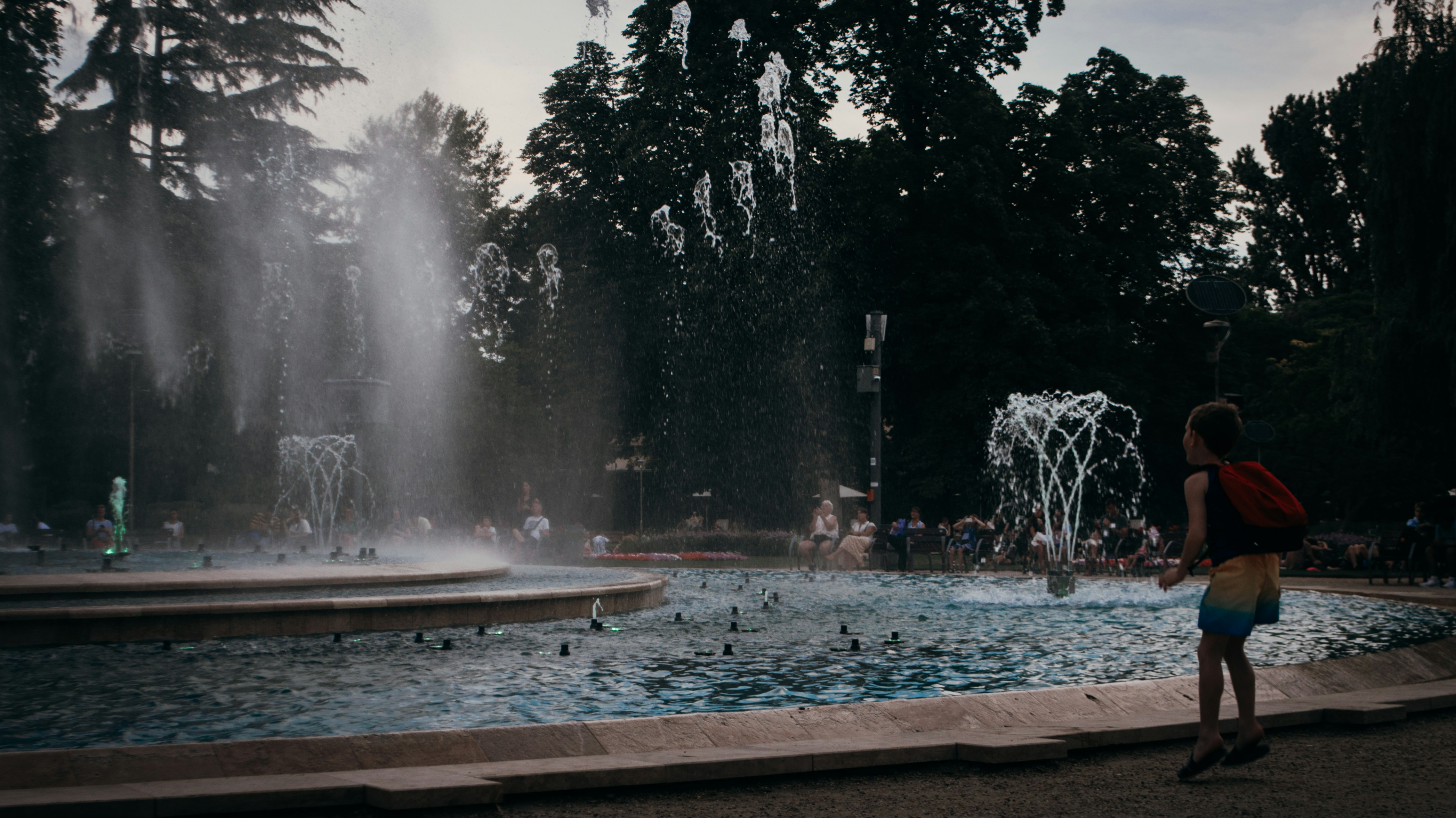Jogger by the Fountain Jets: Quiet Moment at the Park Pool
