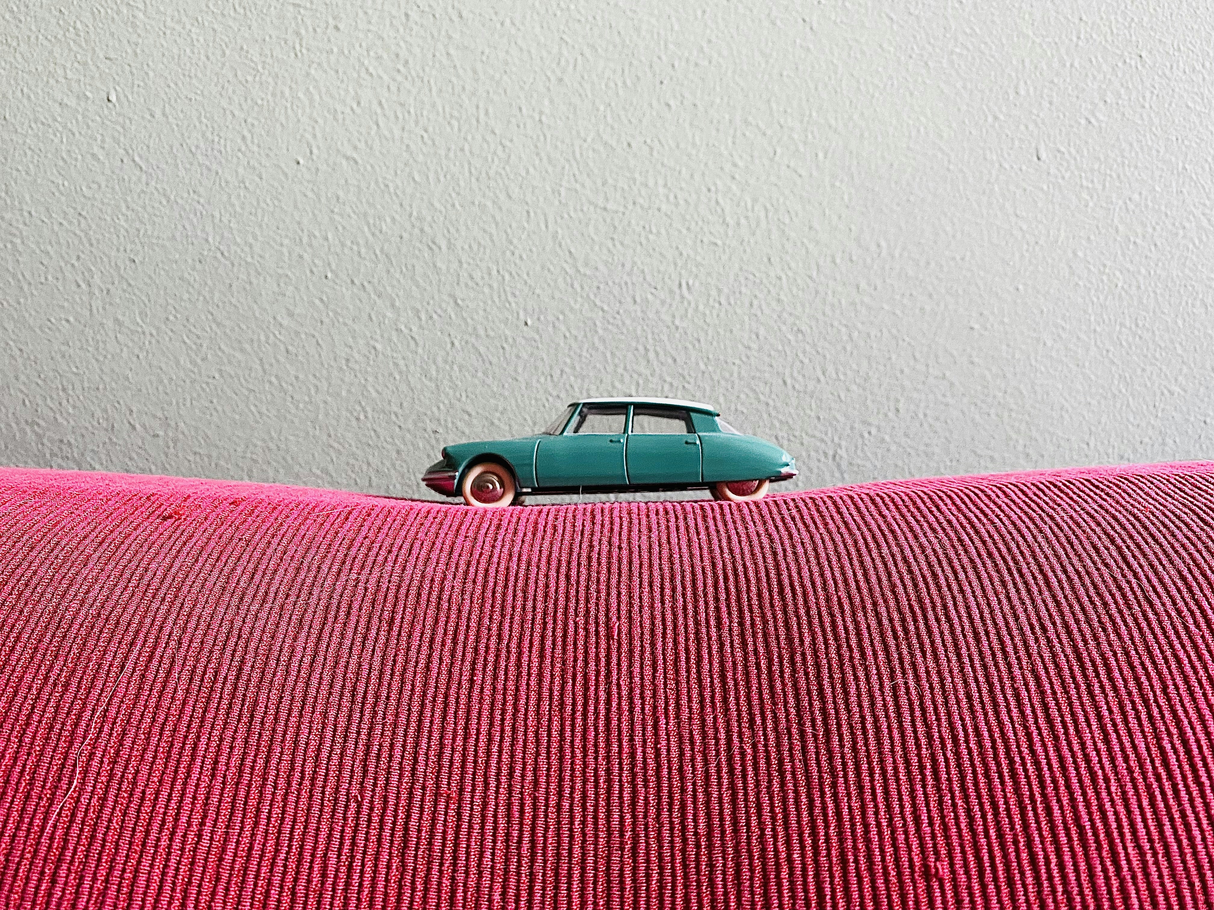 a toy car on a red surface