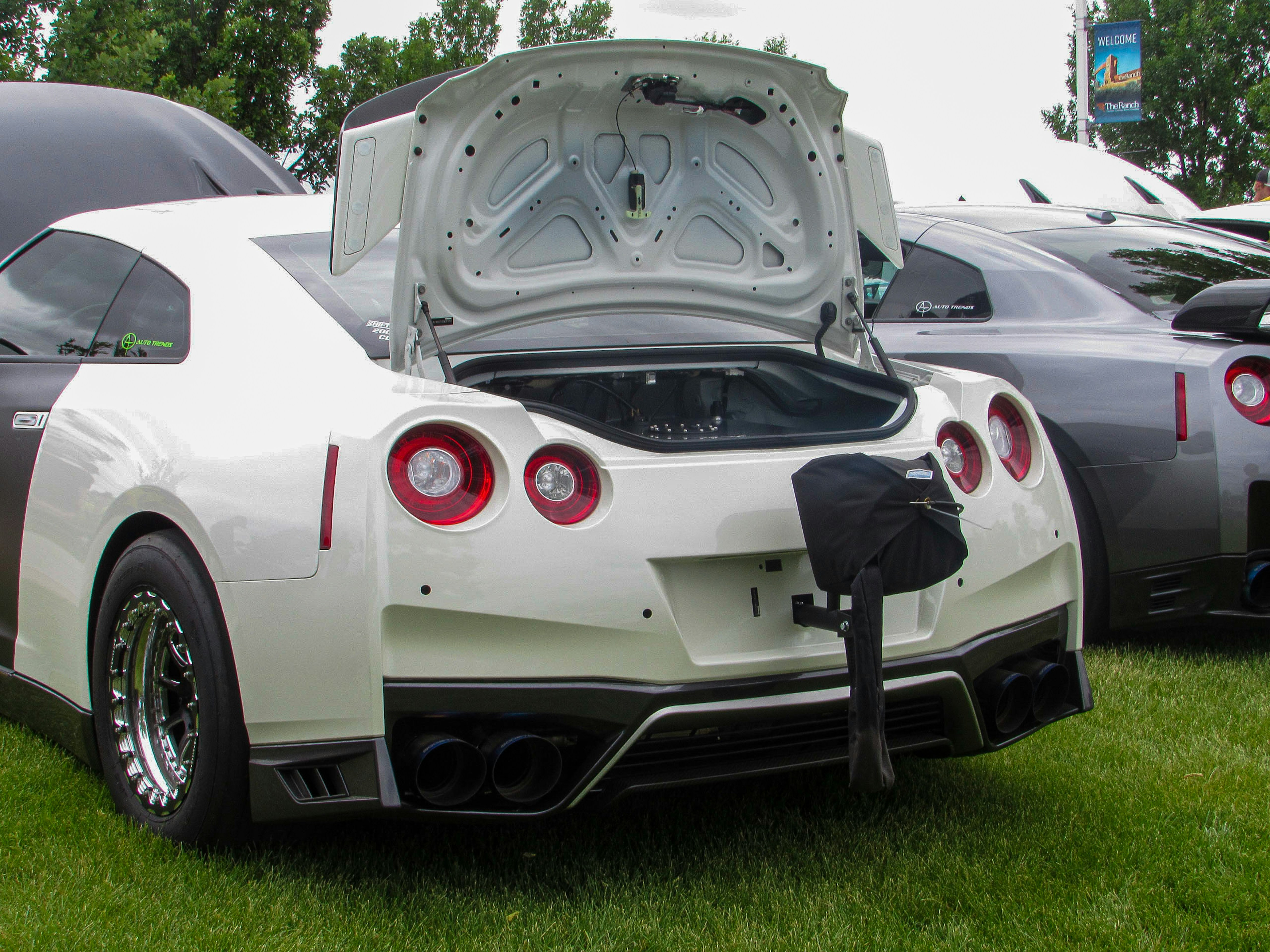 White Nissan GT-R Boot Open at Car Show, Emphasizing Tail and Luggage