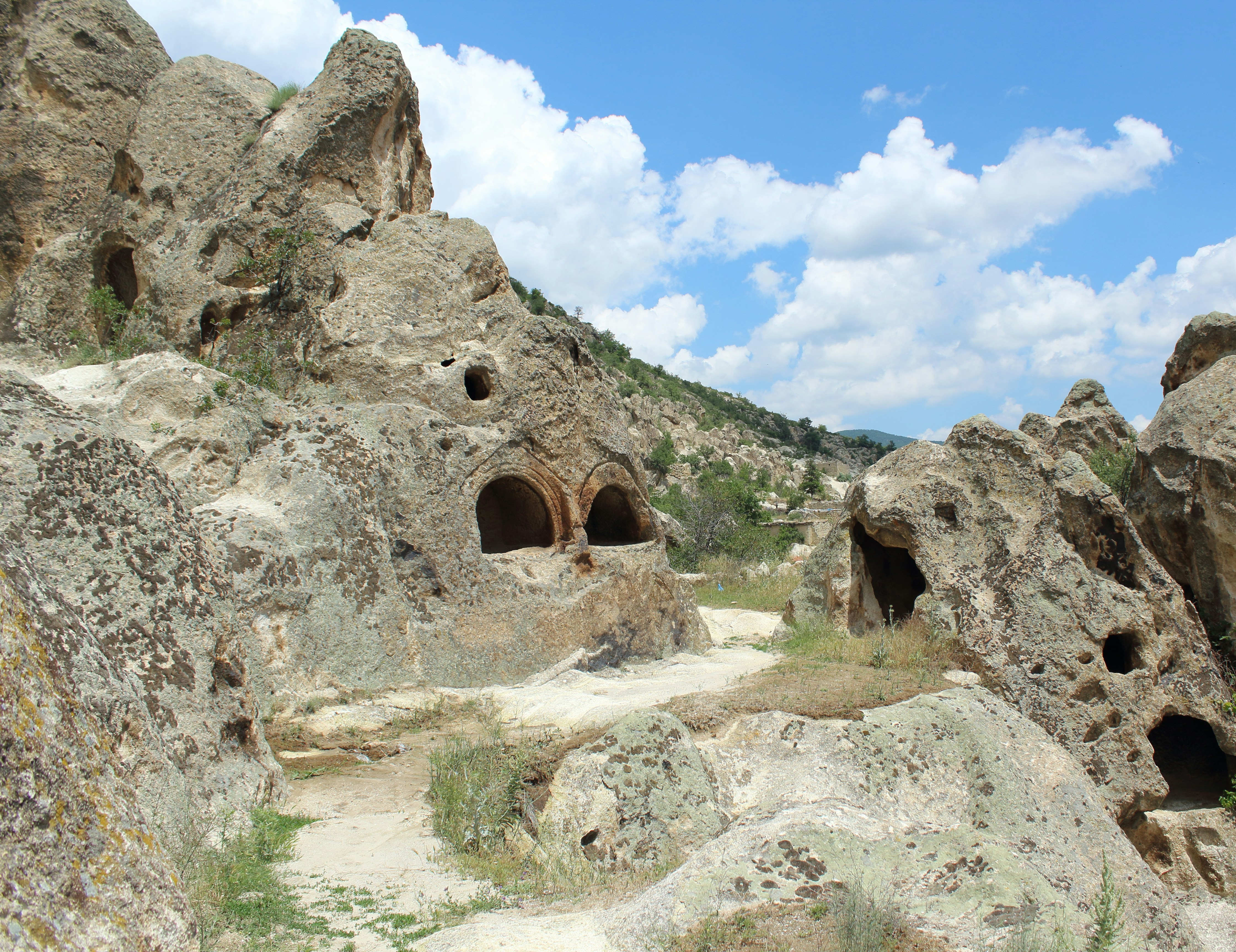 a rocky cliff with a hole in it