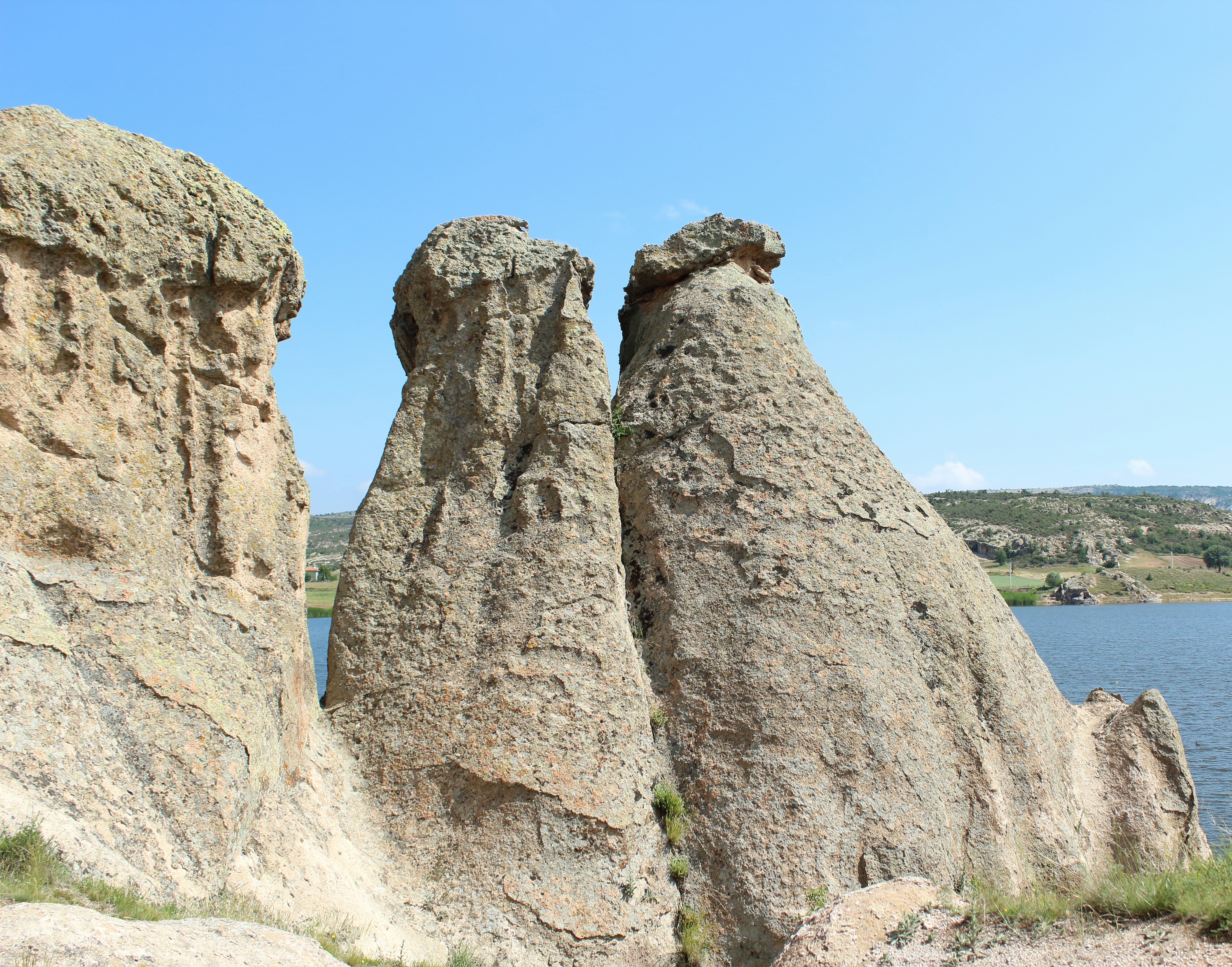 A large rock formation by a body of water photo – Free Rock formation ...
