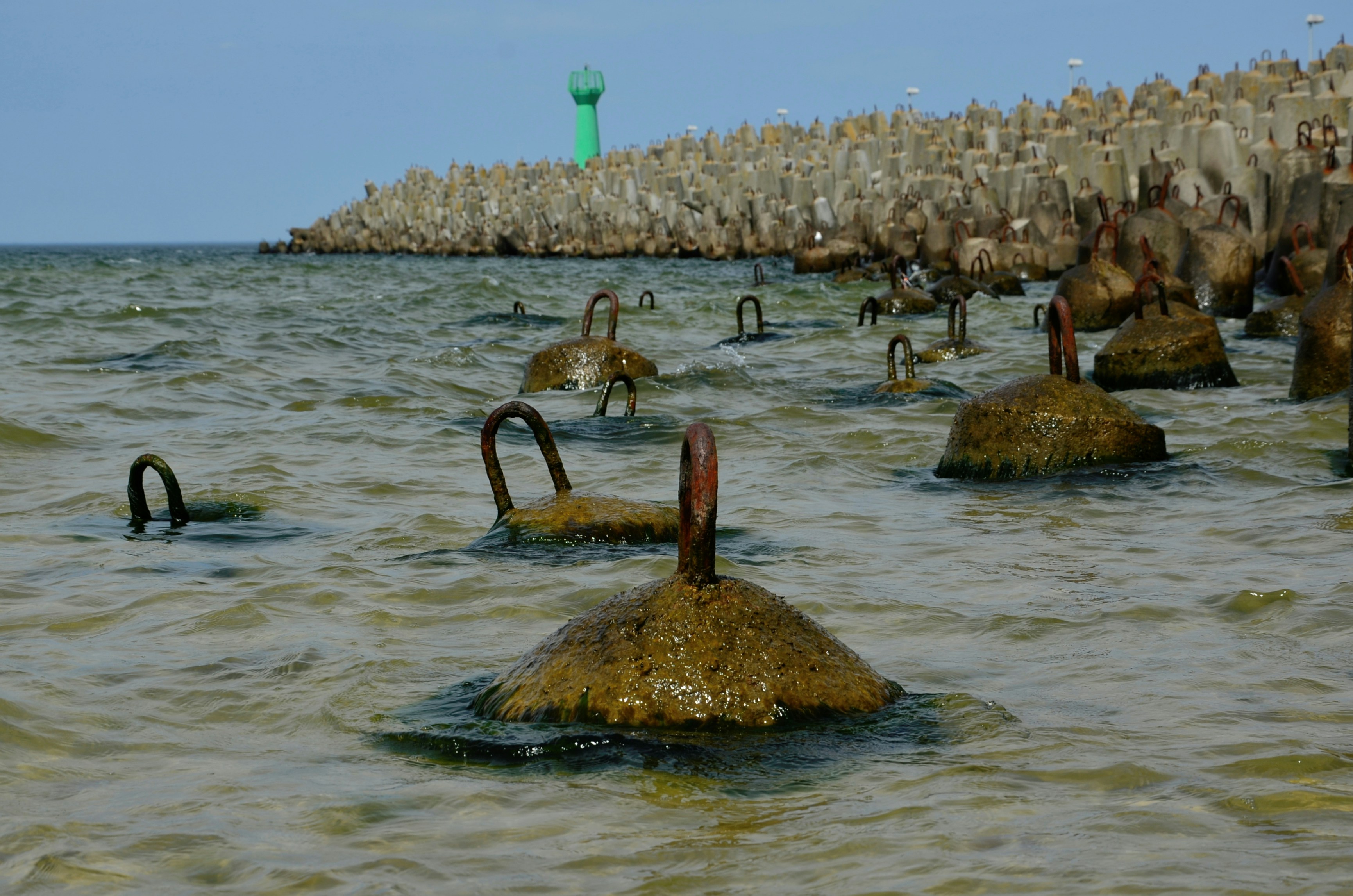 Sea towers: rusted anchors lining a breakwater