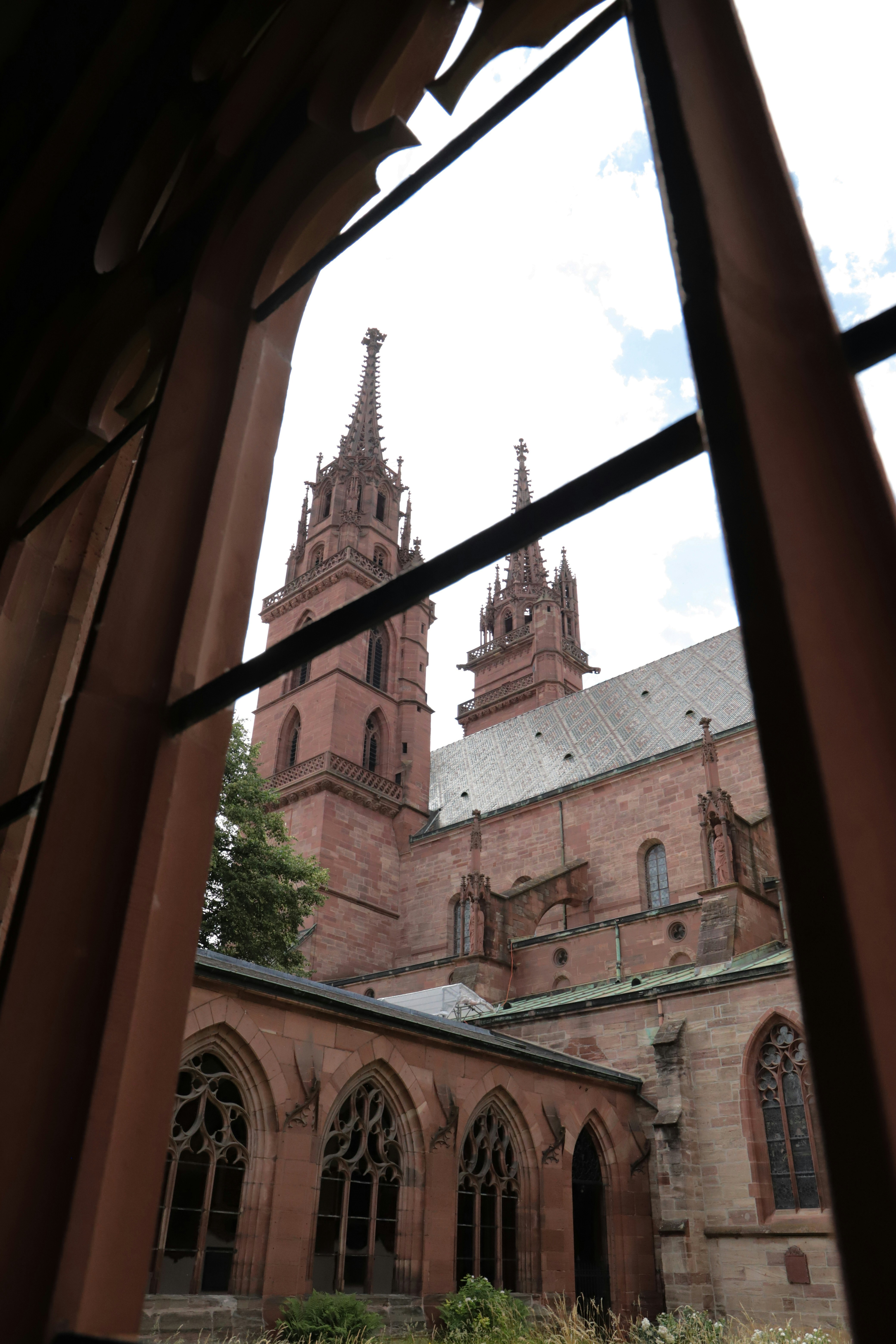 Relics of Brickwork: Gothic Towers Peeking Through a Cloister Window