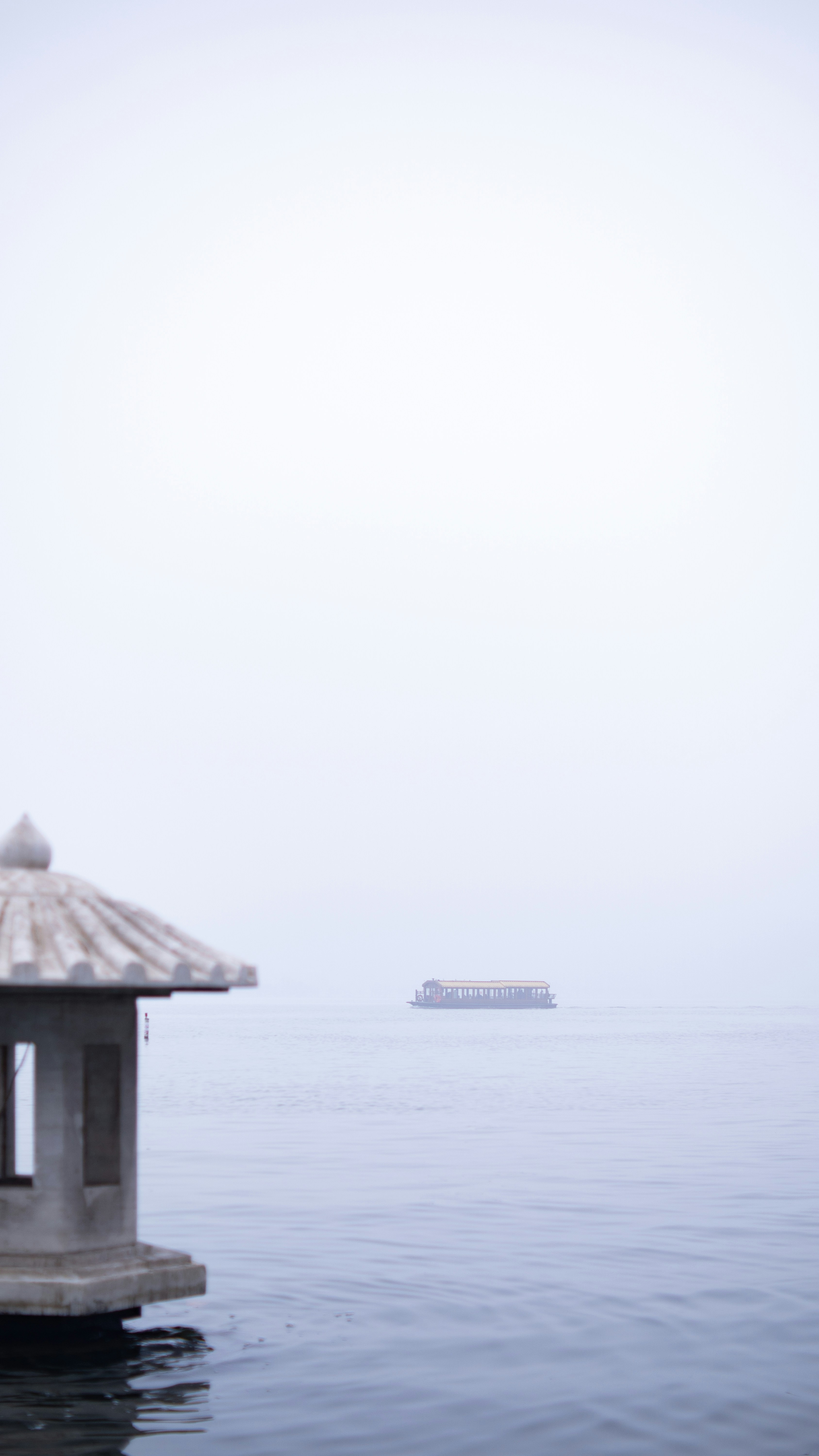 Distant Barque in the Haze: A Quiet Seascape Beyond the Pier