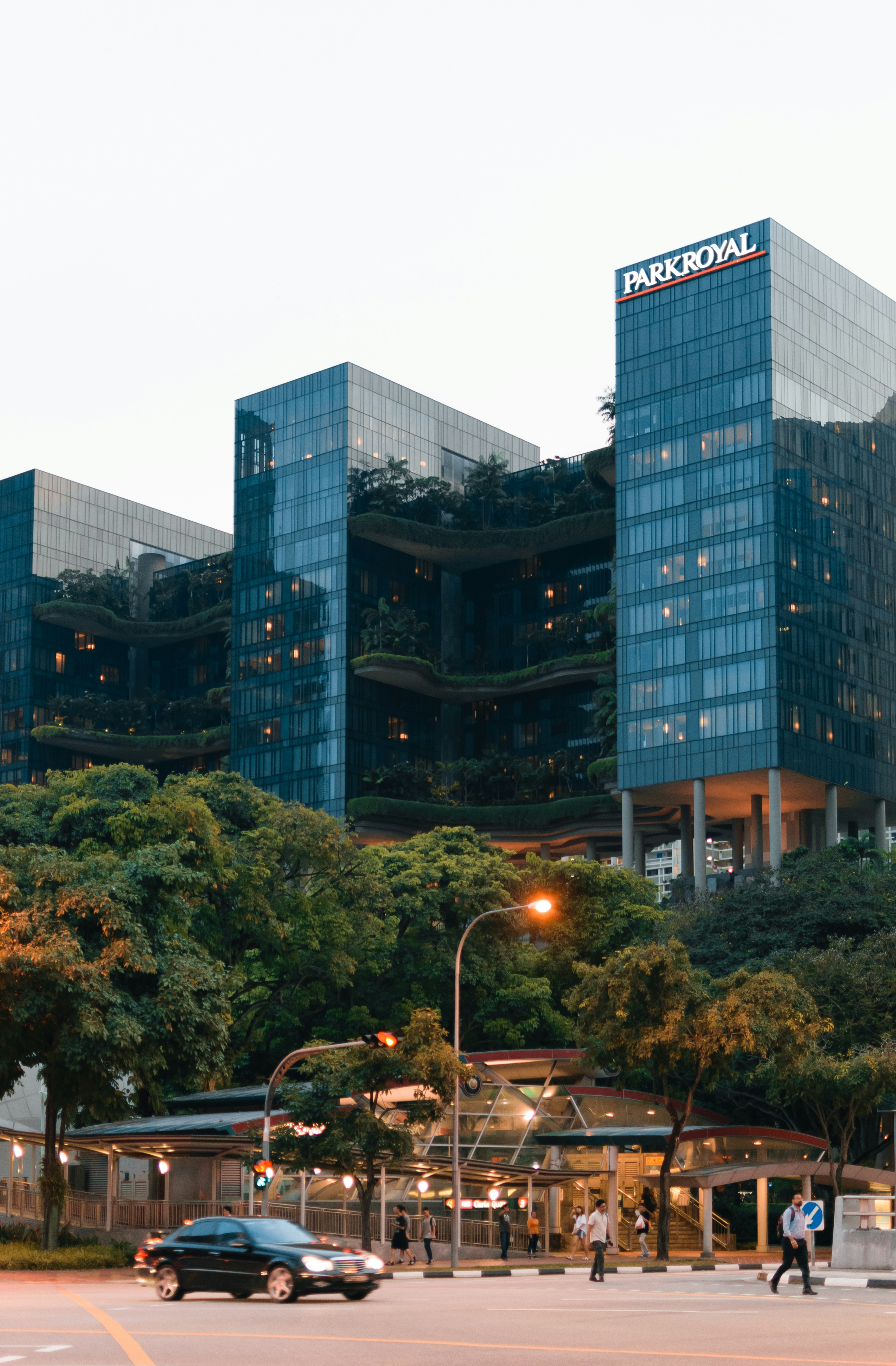 Parkroyal's Verdant Glass Towers Over a Lively Street