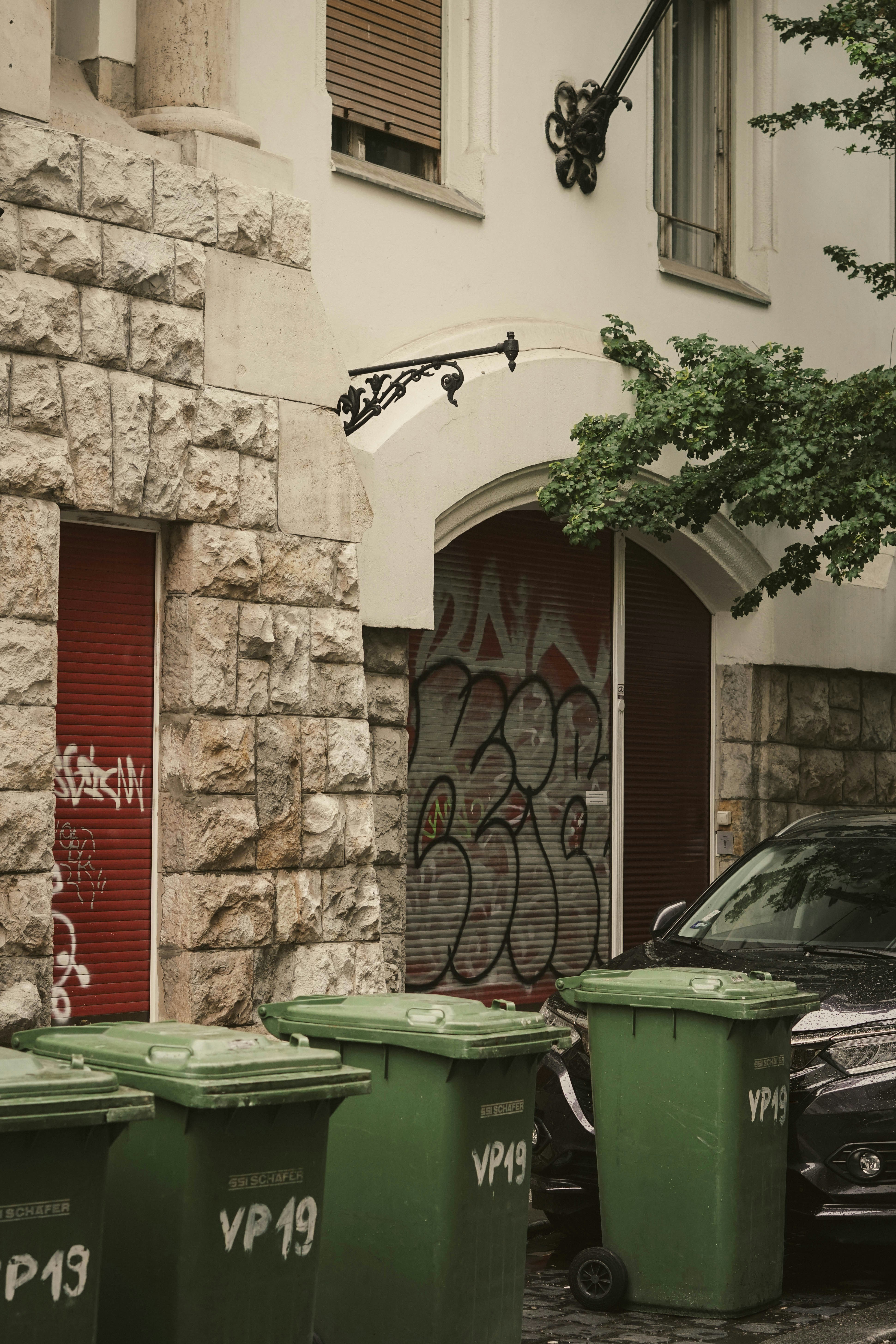 Archway Graffiti and Green Bins: A Sepia-Toned Urban Quiet