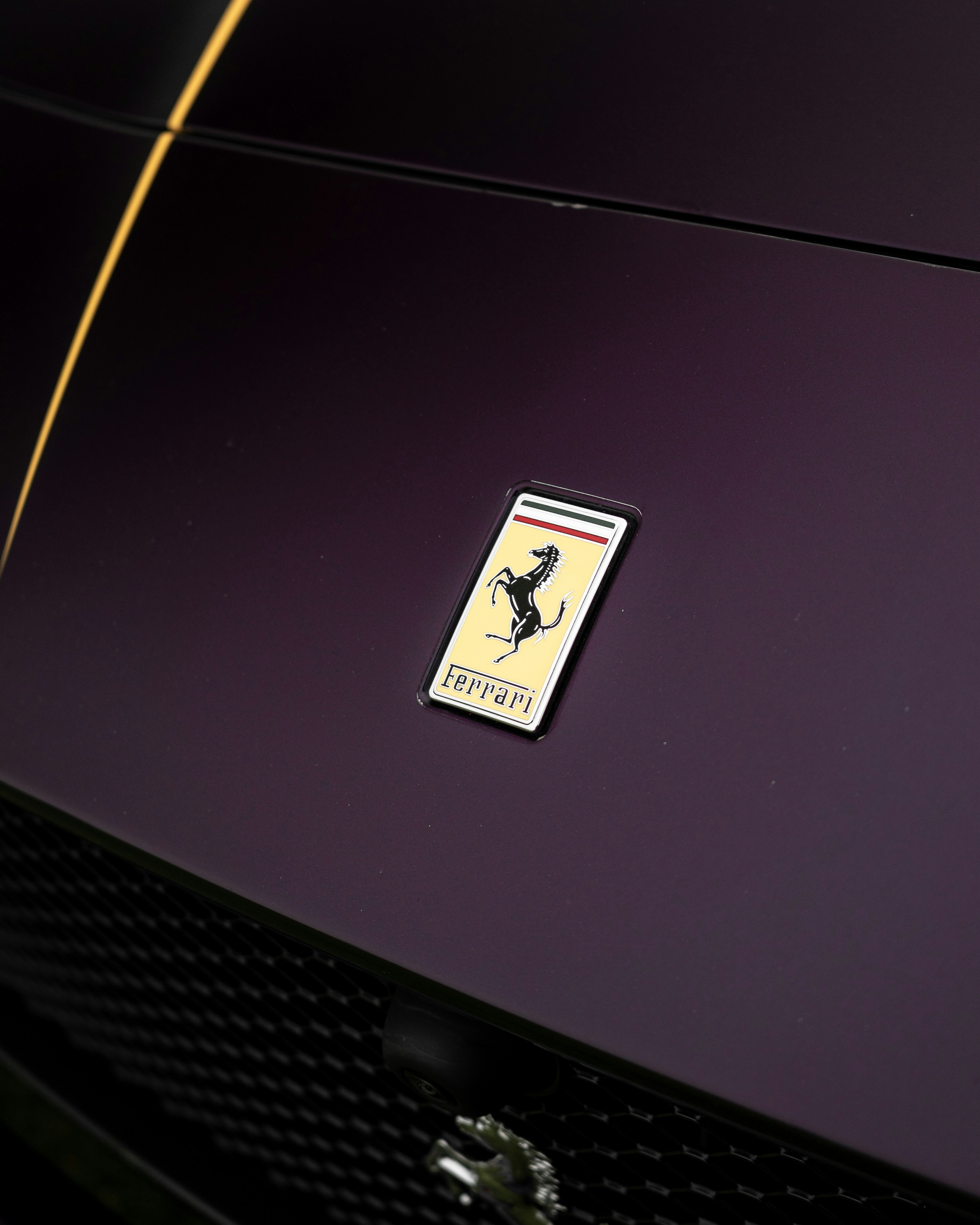 Prancing Crest on Velvet Purple: Ferrari Badge on a Glossy Hood