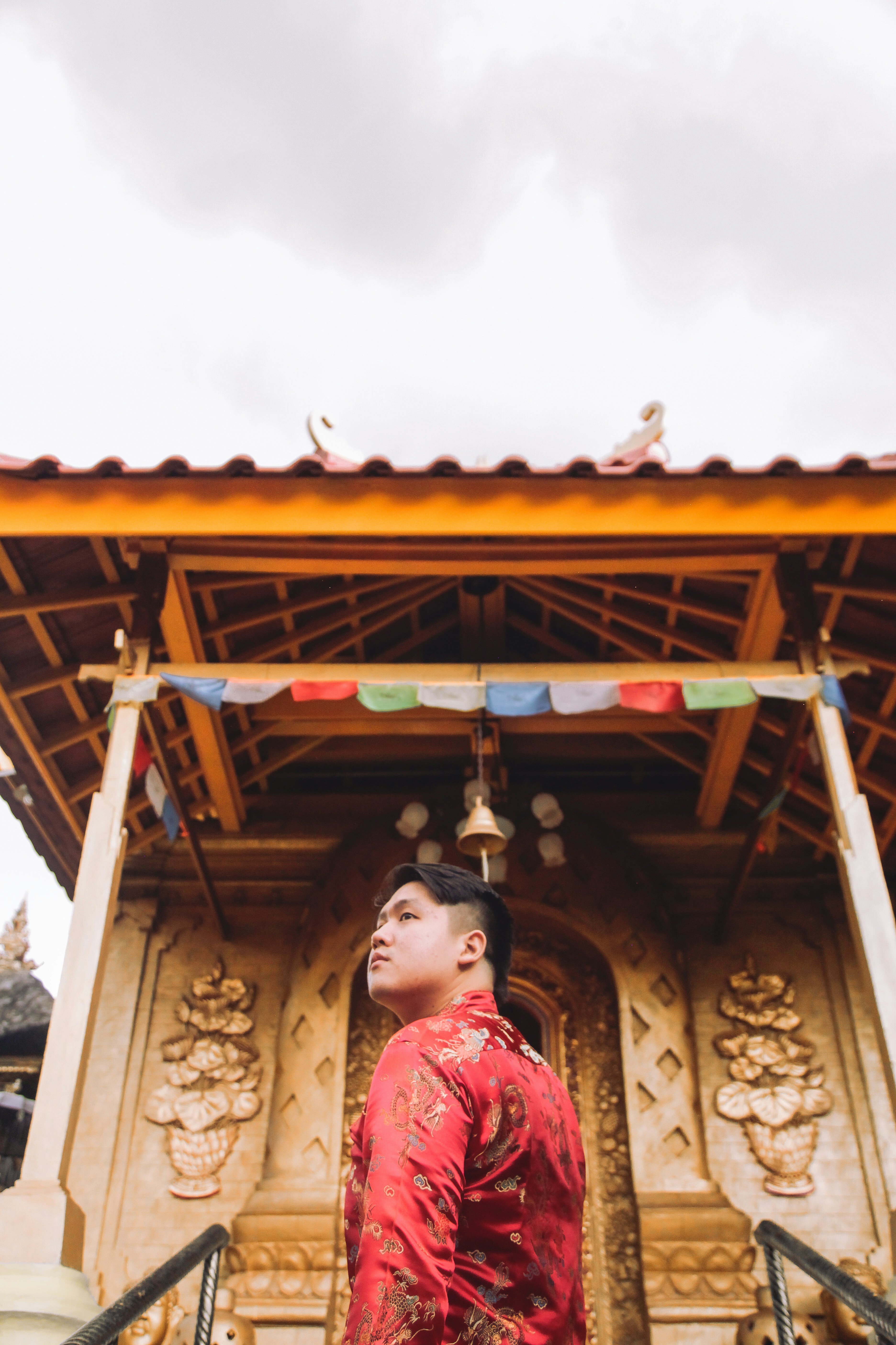 Crimson Attire at the Threshold of Sacred Carvings