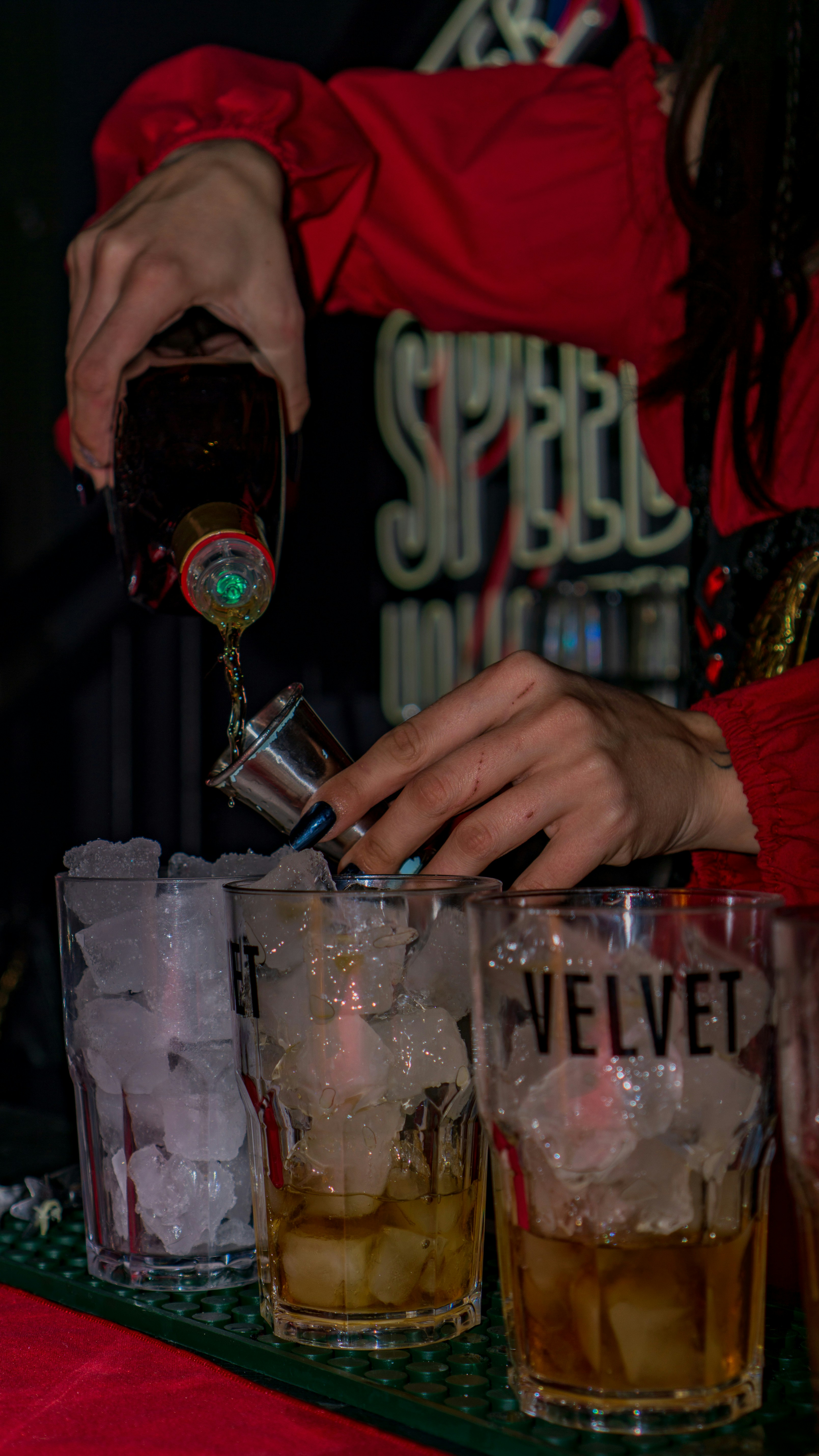a person pouring a drink into glasses