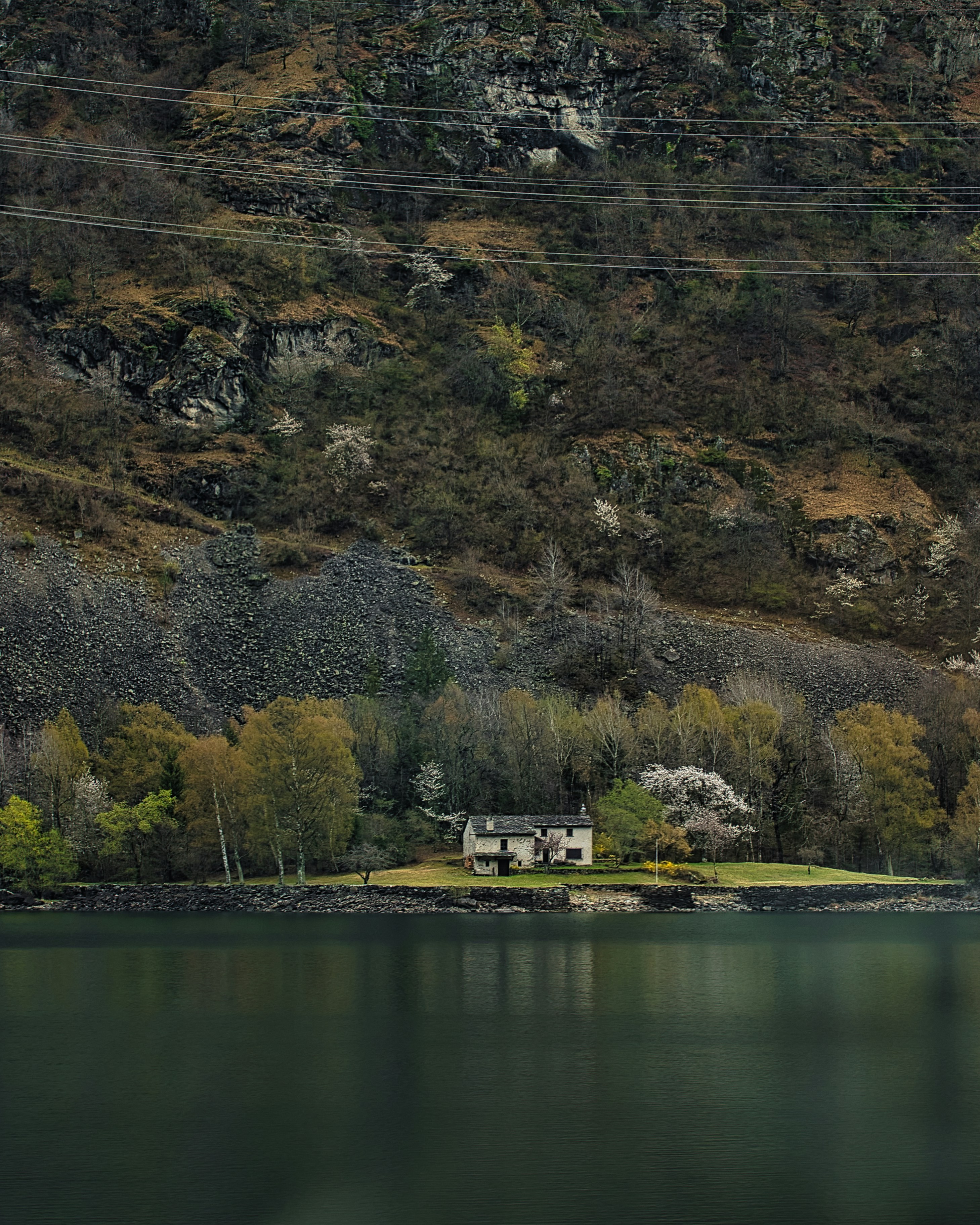 Lakeside Cottage at the Foot of a Weathered Cliff