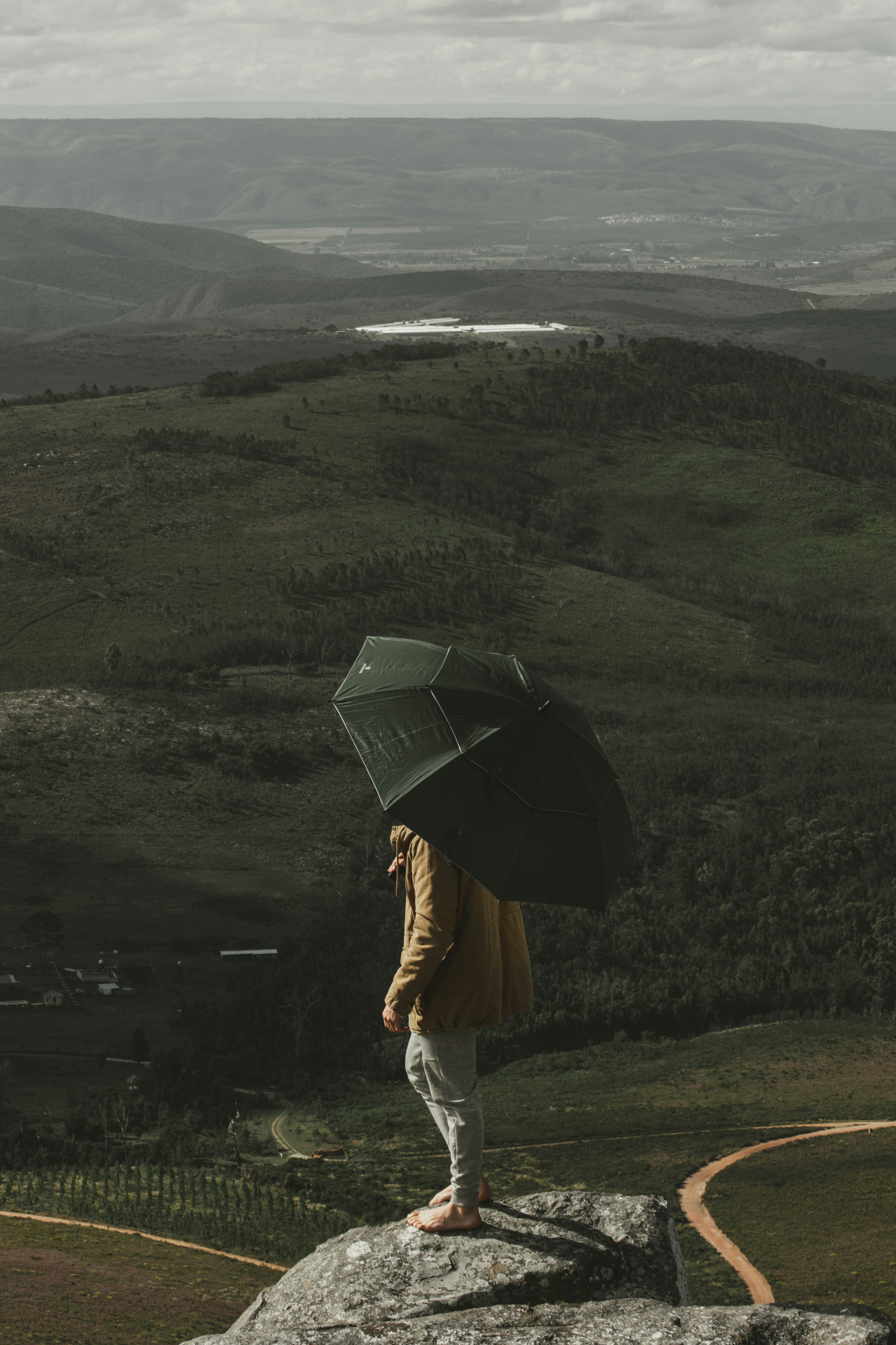 Edge of the Moor: A Lone Figure with Umbrella on the Rock