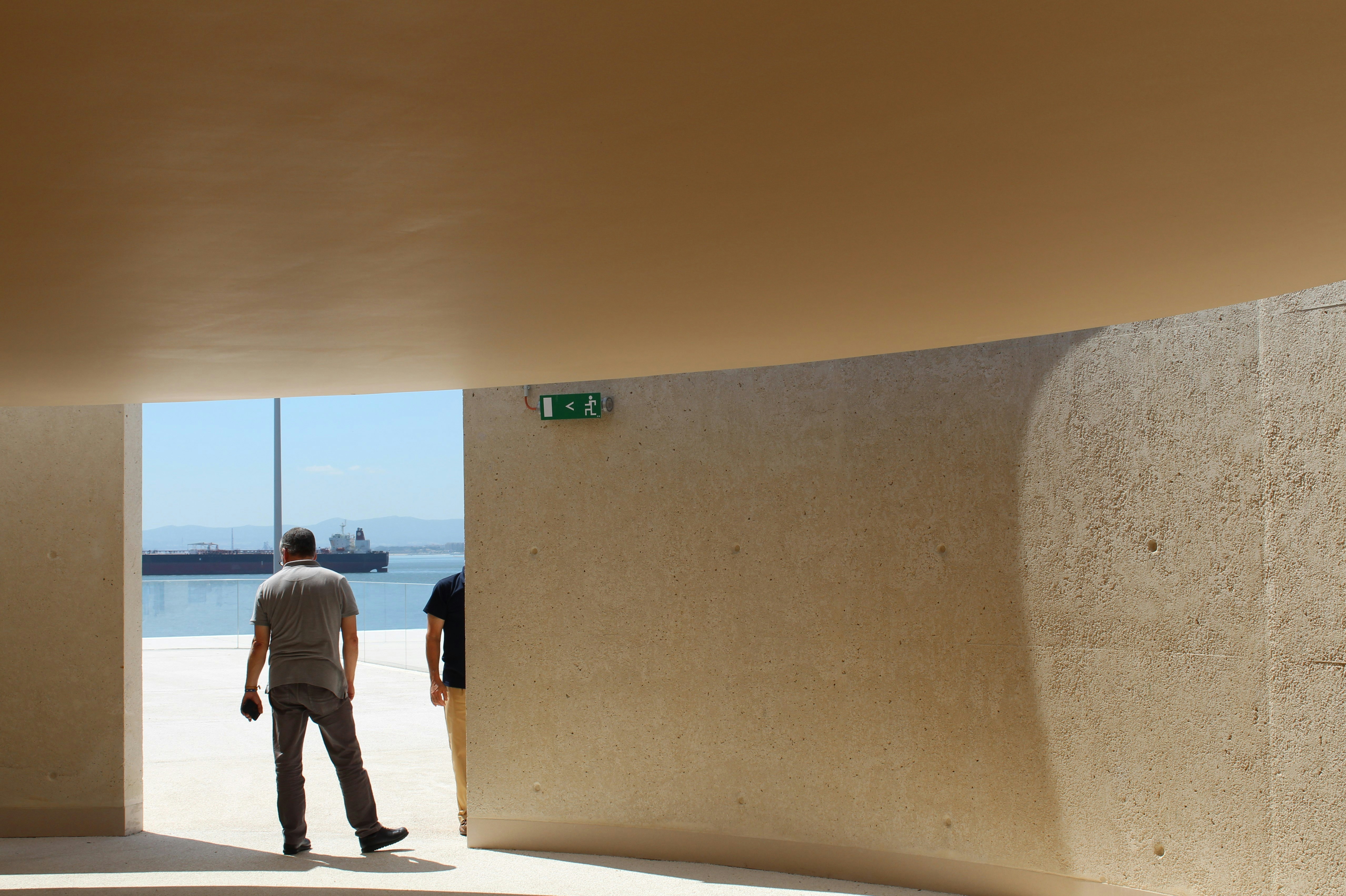 A couple of people looking out a window at the ocean photo – Free ...