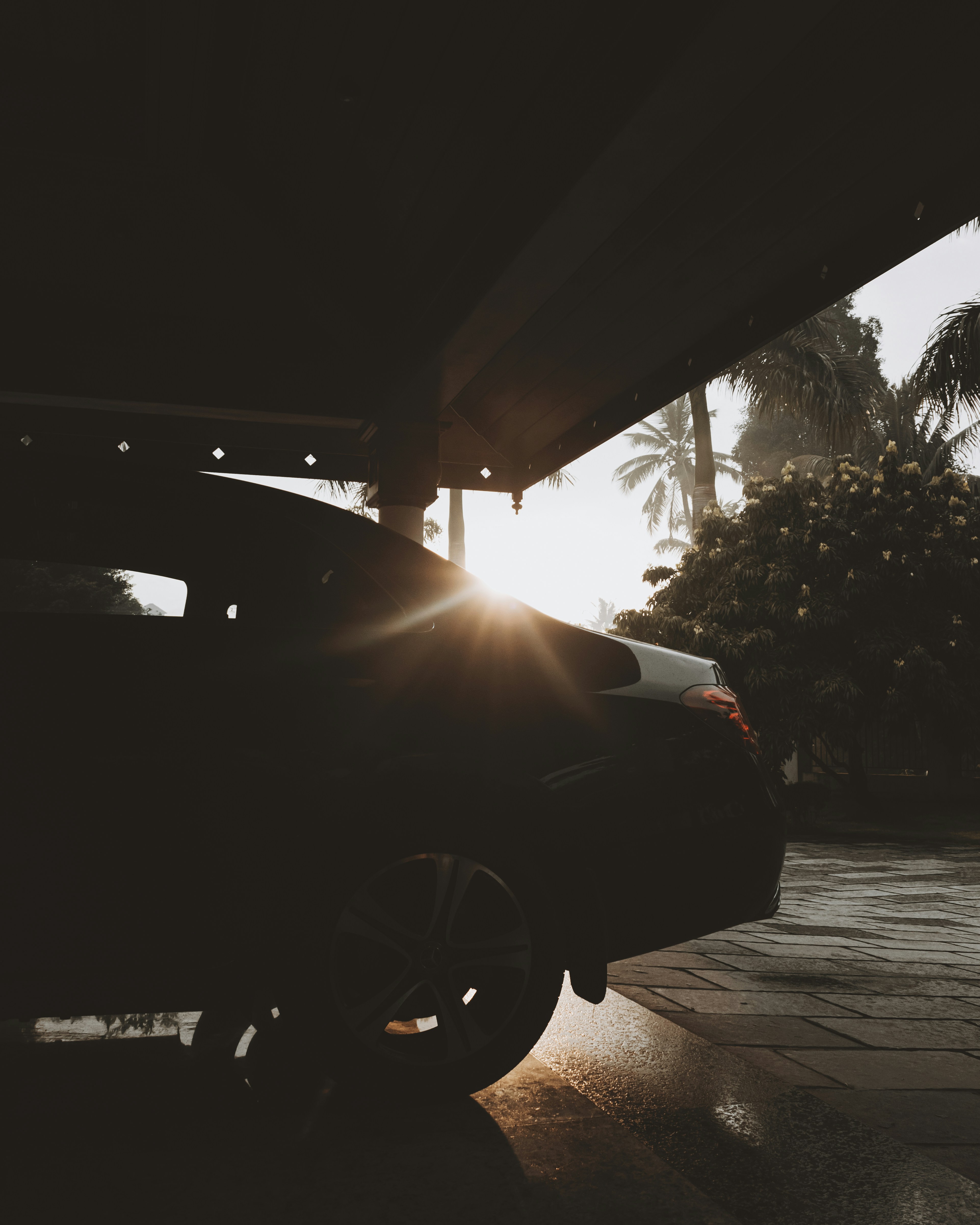 Sunburst Behind a Sheltered Sedan: A Quiet Backlit Moment