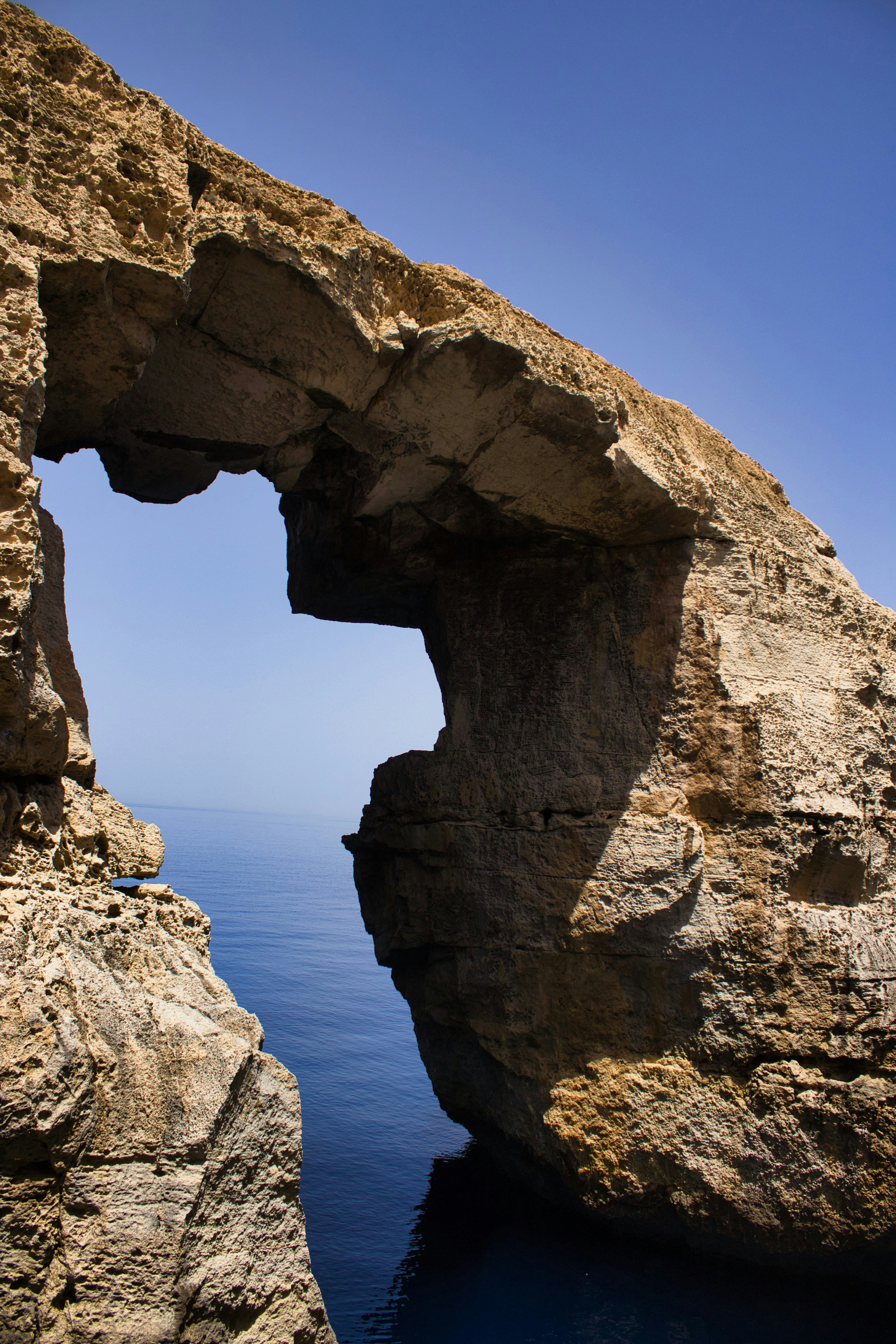 A large rock arch over a body of water photo – Free Sea Image on Unsplash