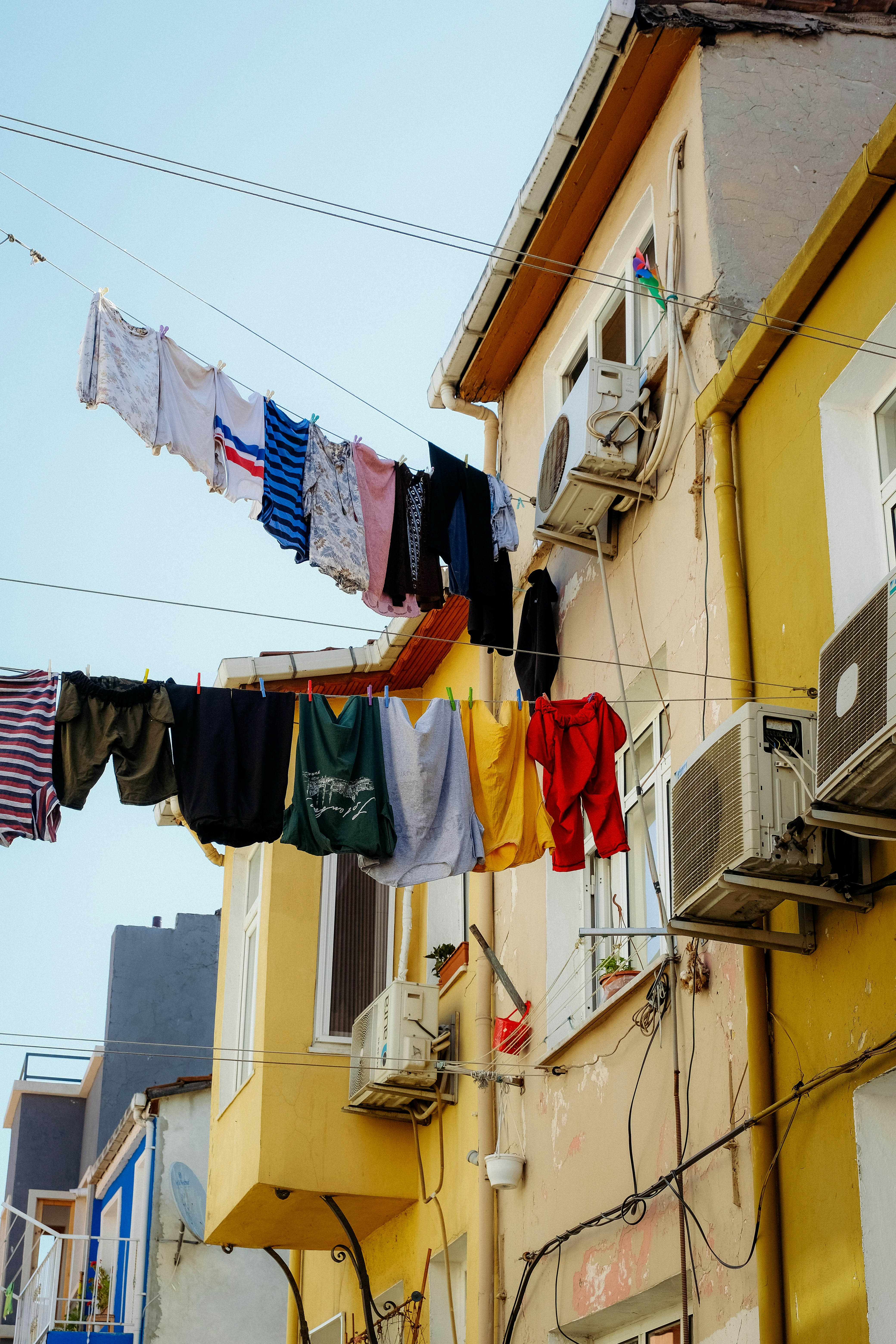 Colorful clothes hanging on a line between buildings, showcasing urban life and domestic routines in a vibrant neighborhood.