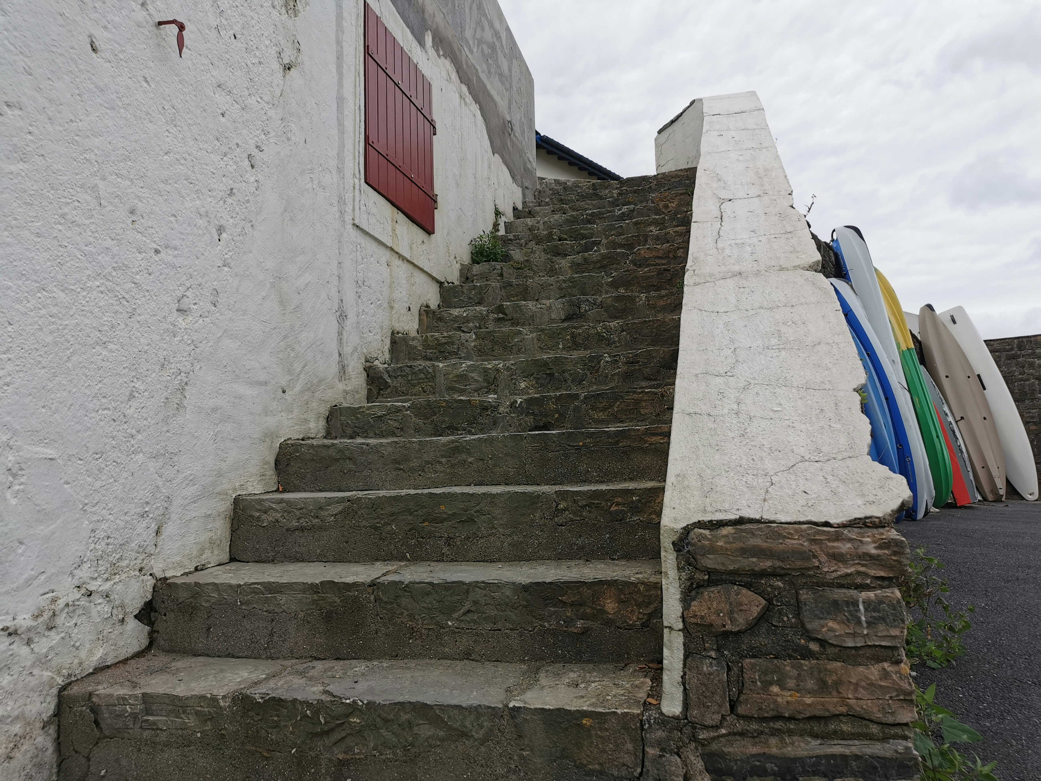 Weathered Concrete Staircase Framing a Surfboard Row