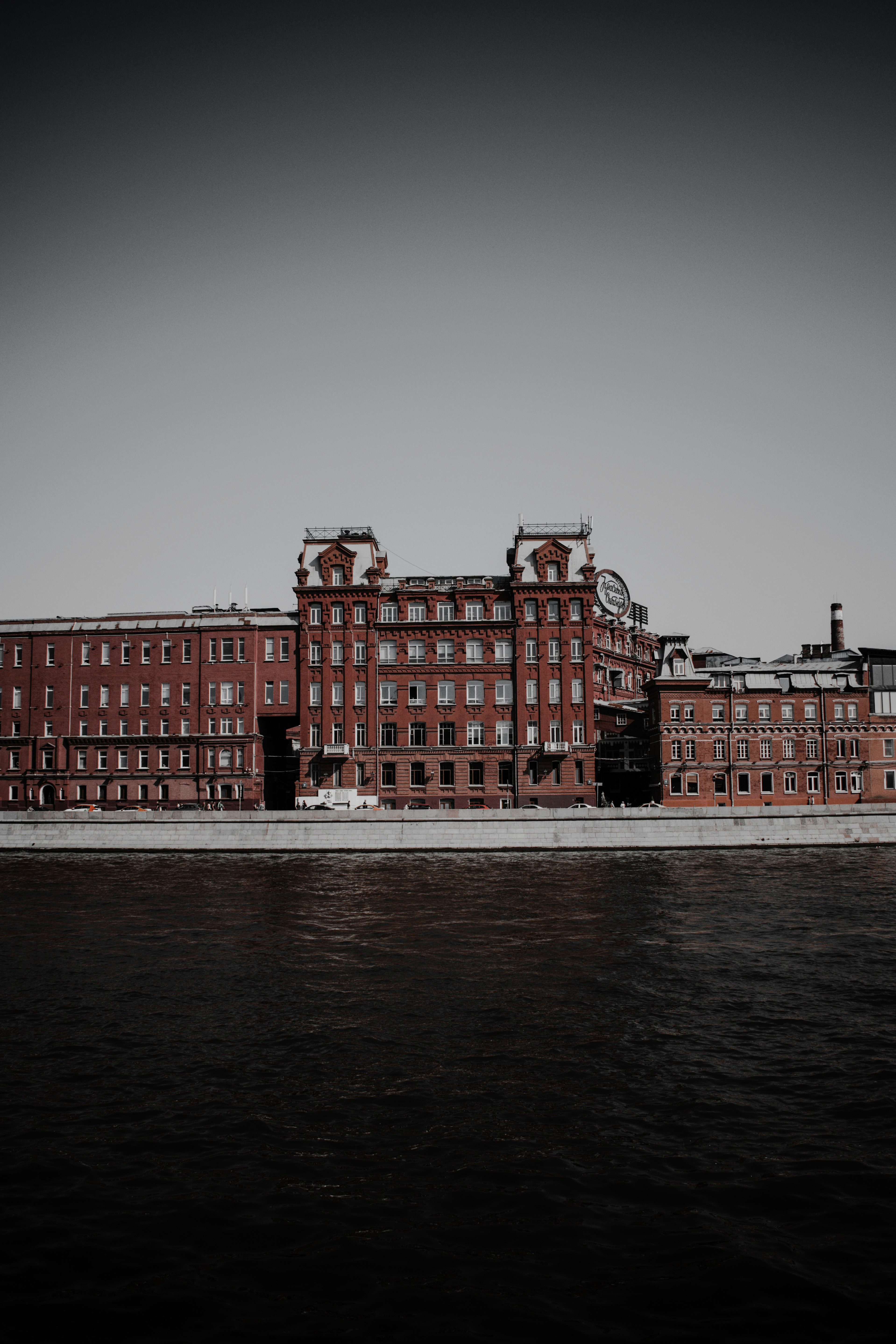 Brick Riverfront Monolith: A Row of Red Factory Buildings on the Water