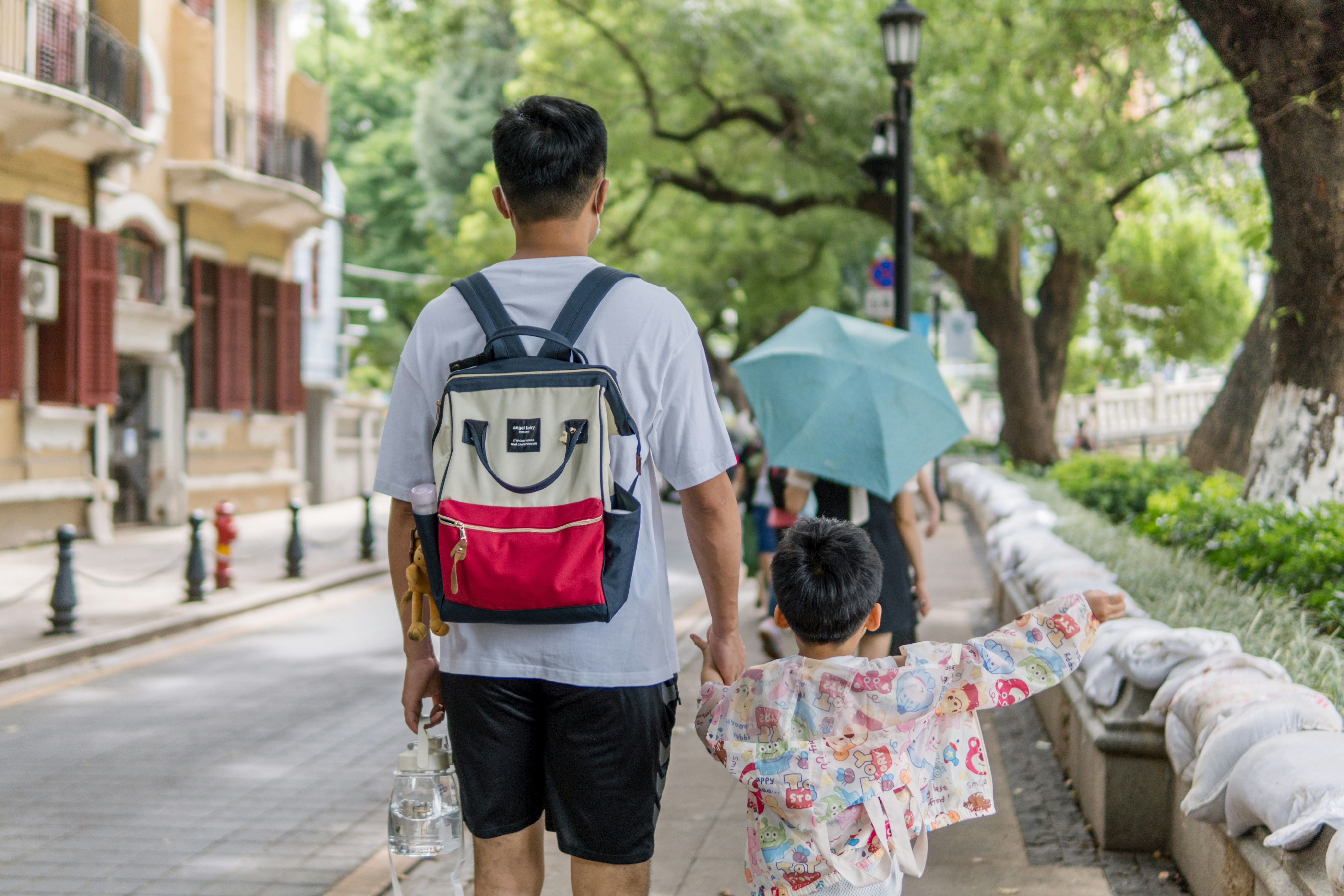 a man and a woman walking down a sidewalk with an umbrella