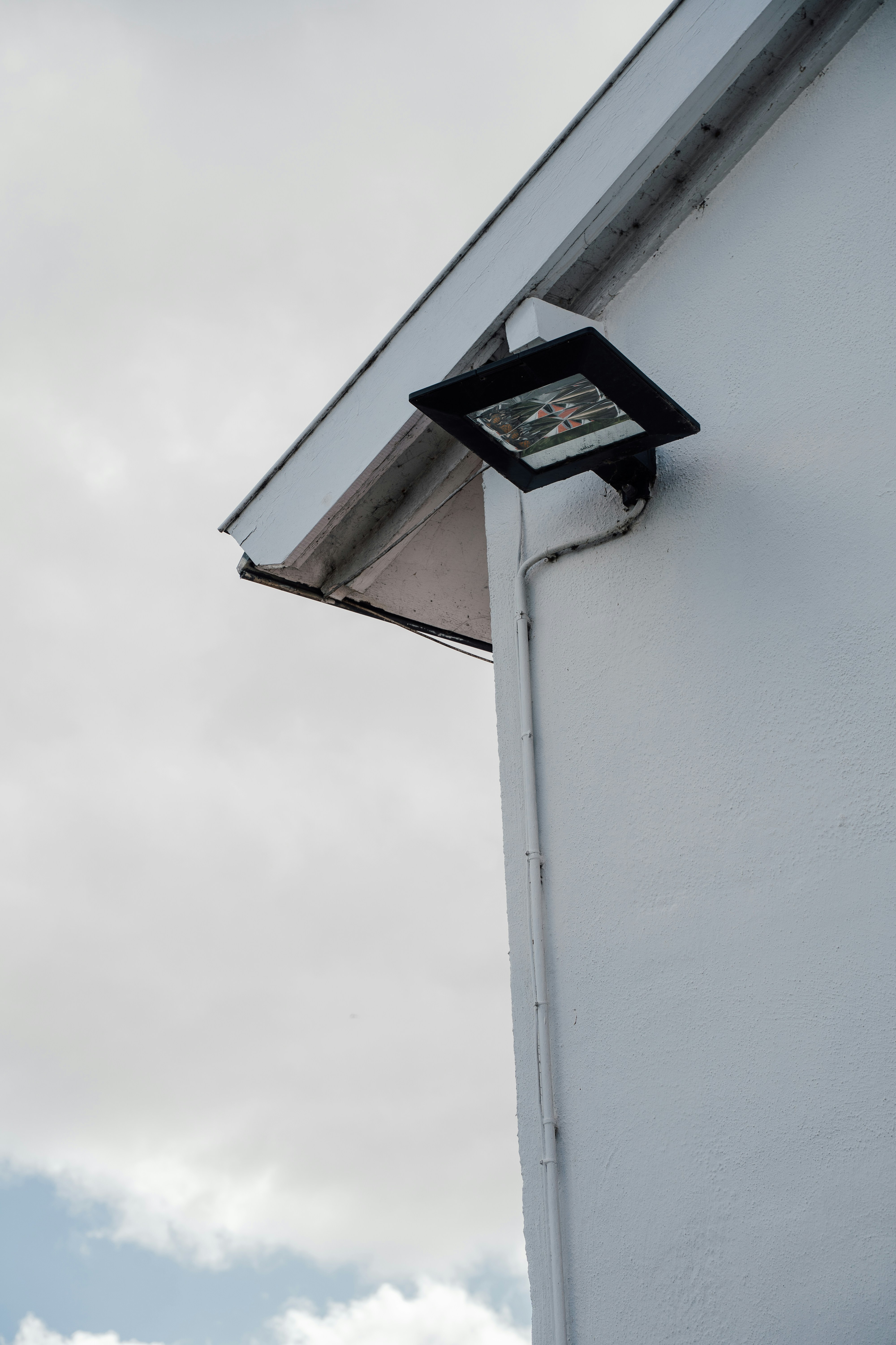 External Wall Light Casting a Subtle Glow Against a Pale Facade