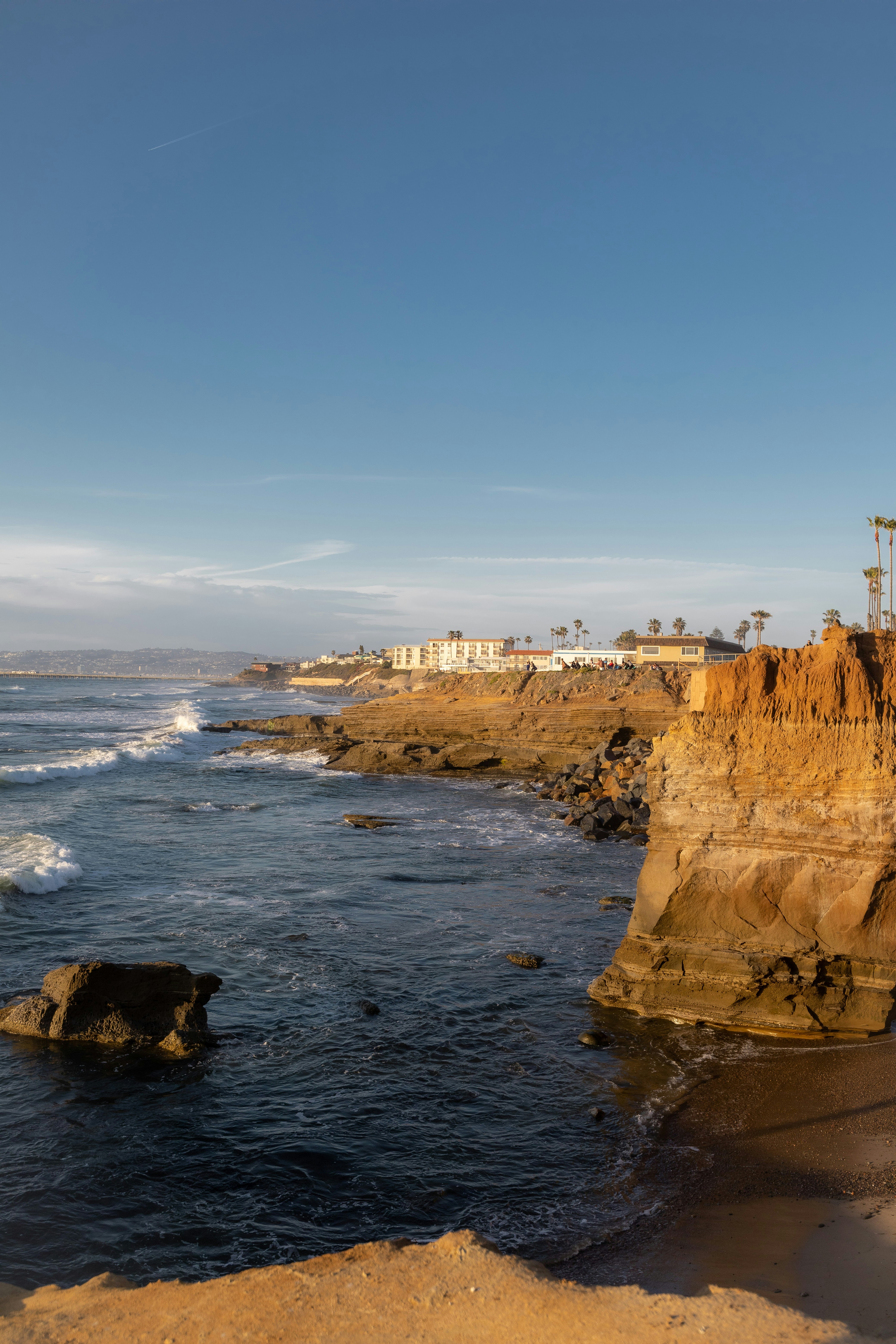a rocky beach with a building on the shore