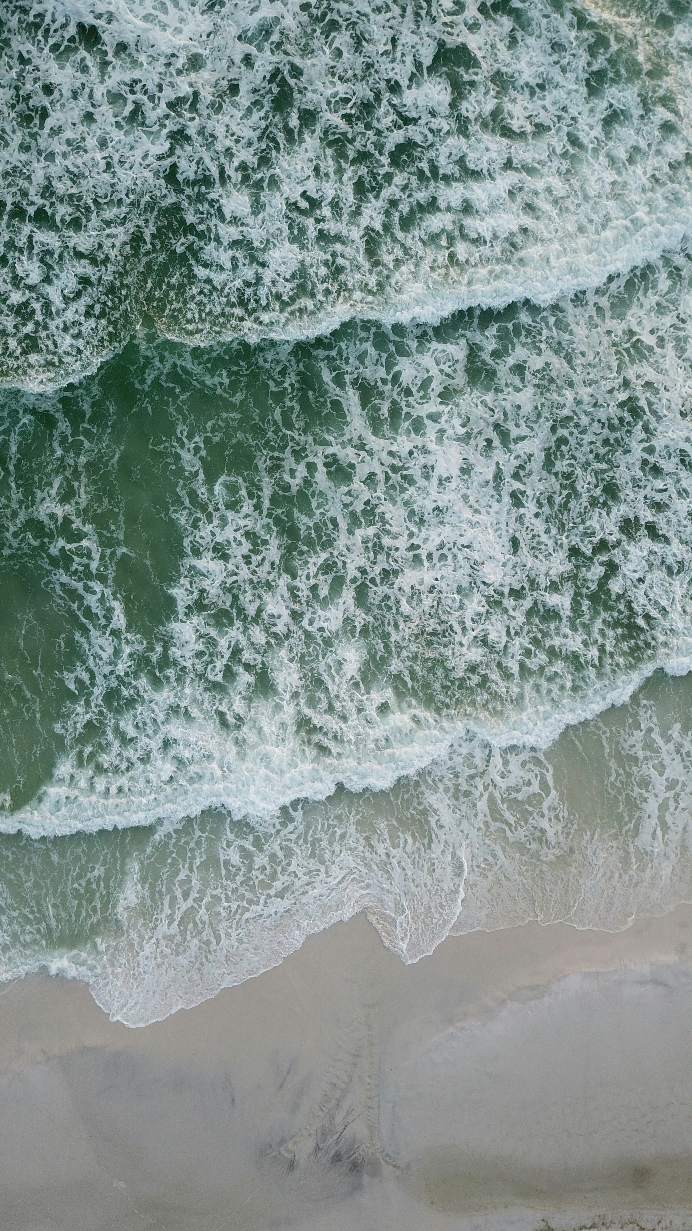 Une vague s’écrasant sur une plage photo – Photo Gris Gratuite sur Unsplash