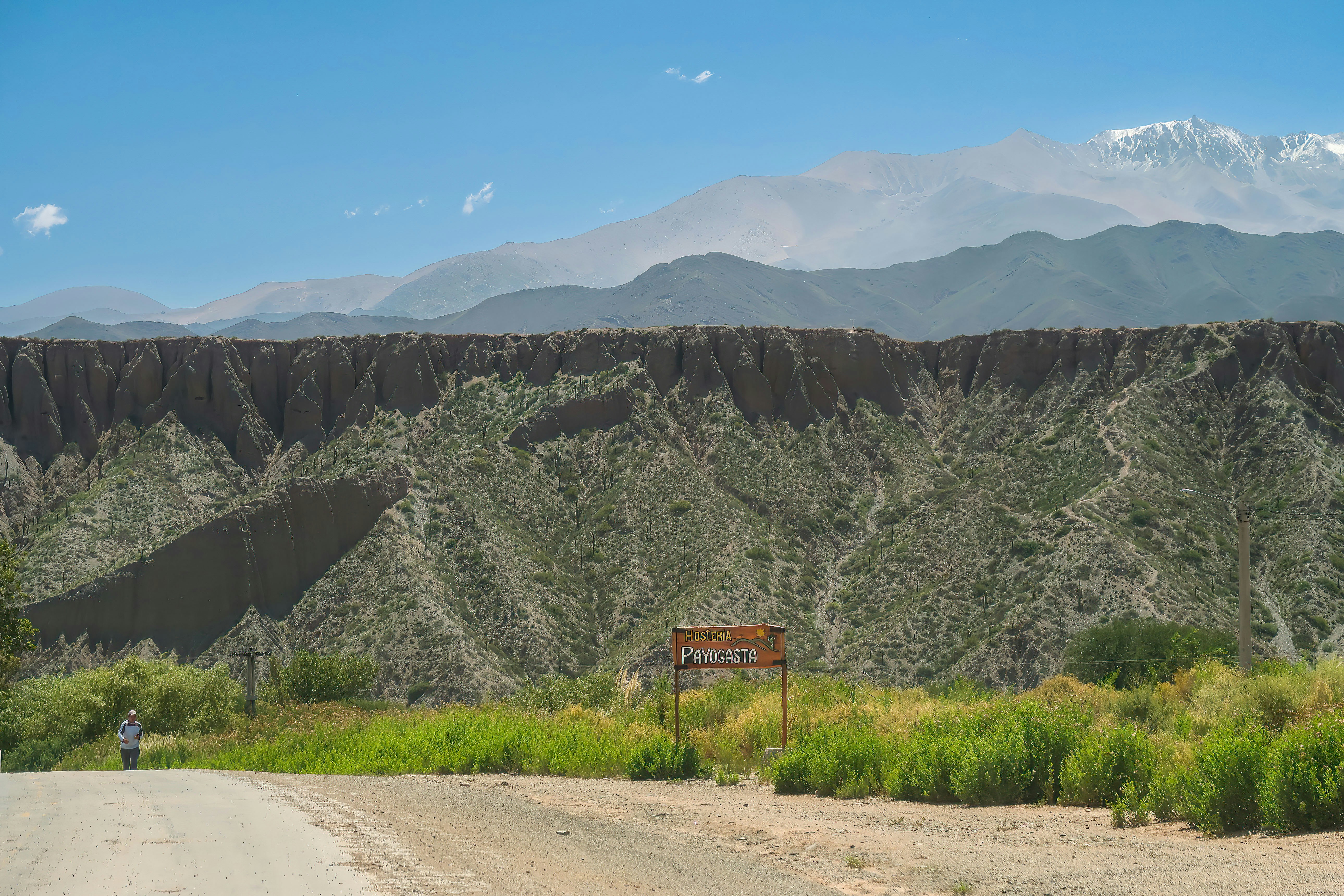 Foto Un letrero al costado de una carretera con montañas al fondo ...