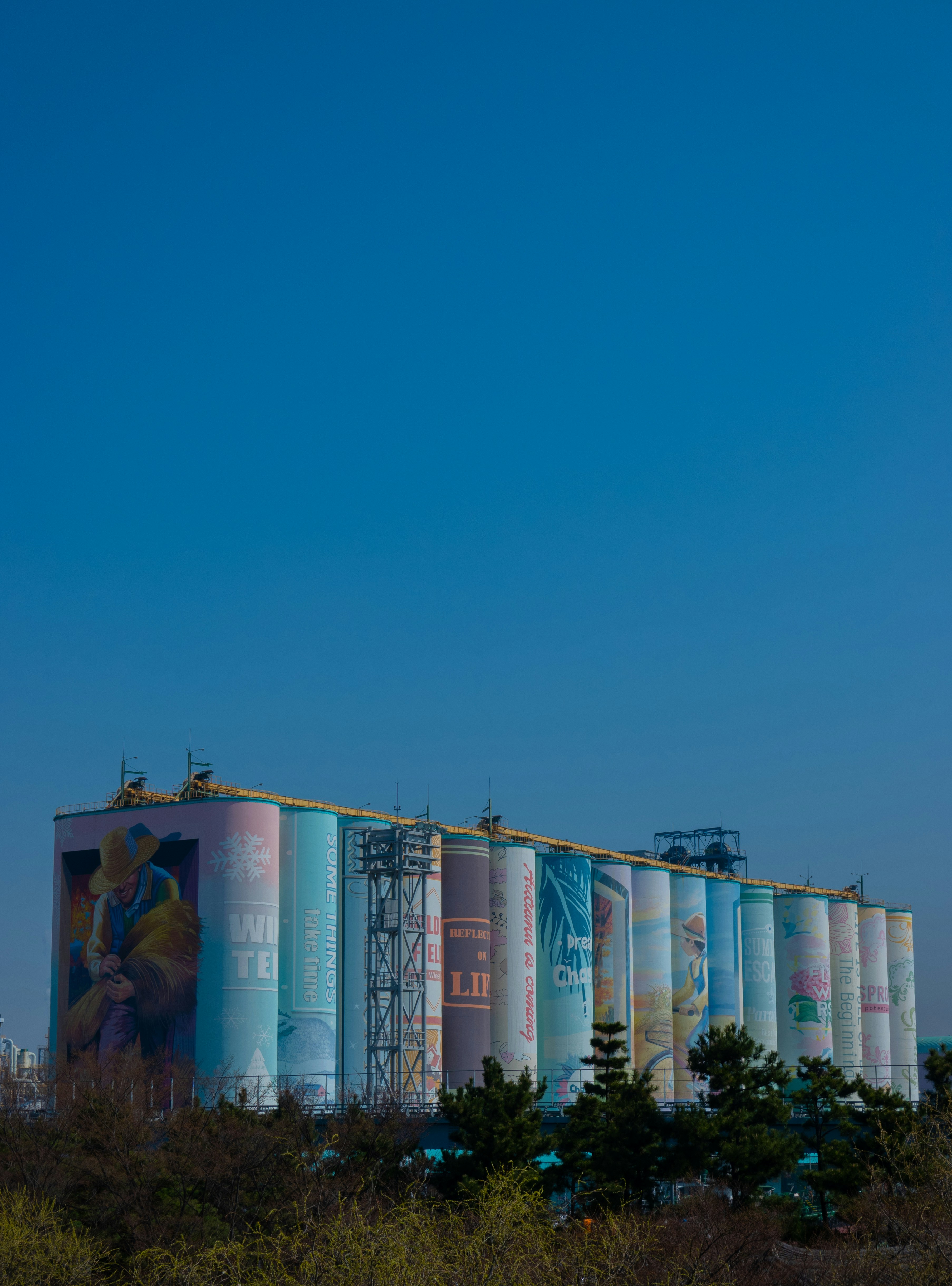 Crescendo of Silos: Colorful Cylinders Against a Clear Sky