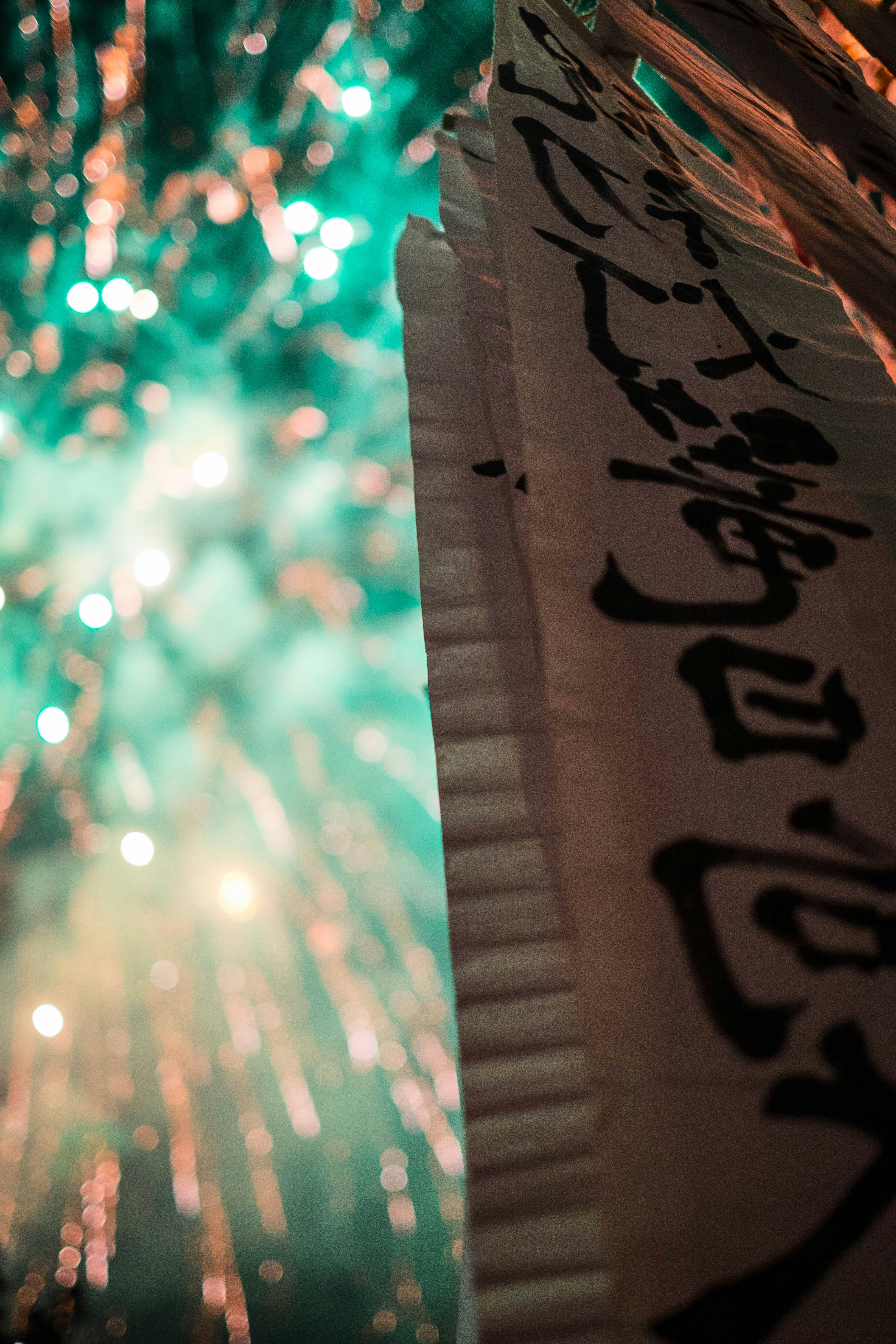 Vertical Banner and Fireworks: A Night of Paper Signs Beneath Skewed Celebration Lights