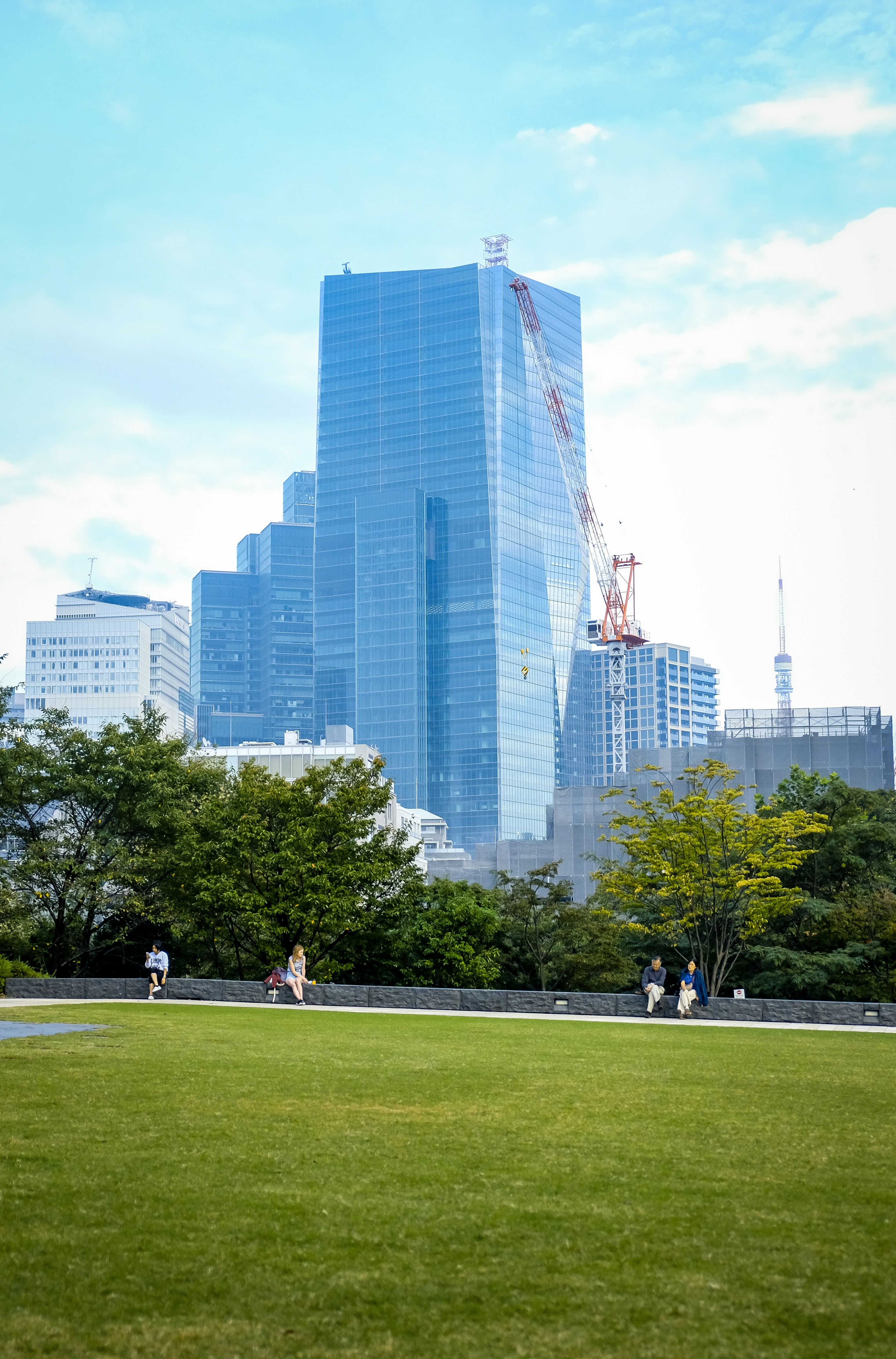 Azure Glass Tower Looms Over a Tranquil City Park