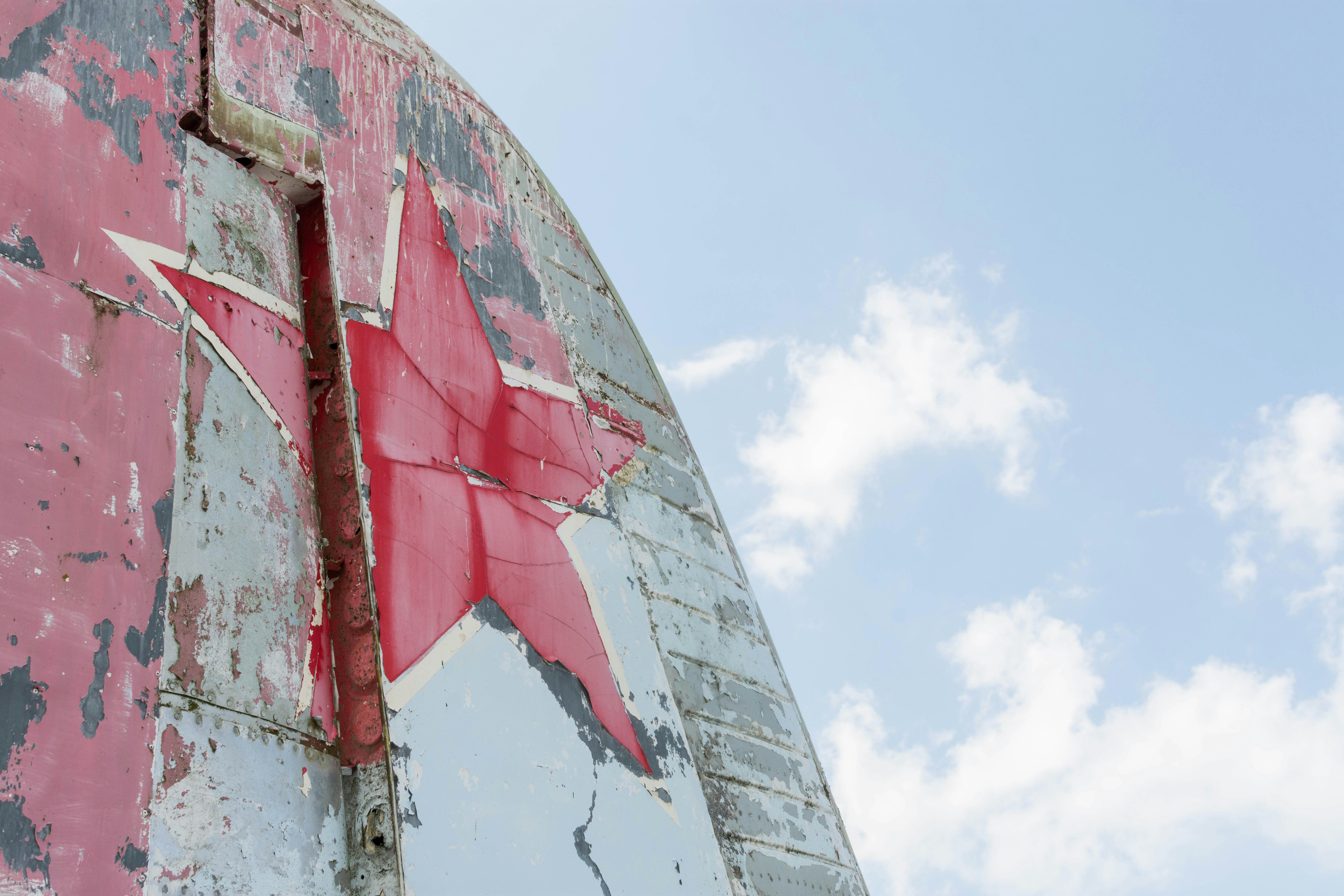Cracked Neon Star on a Weathered Signhead Reaching Toward the Sky