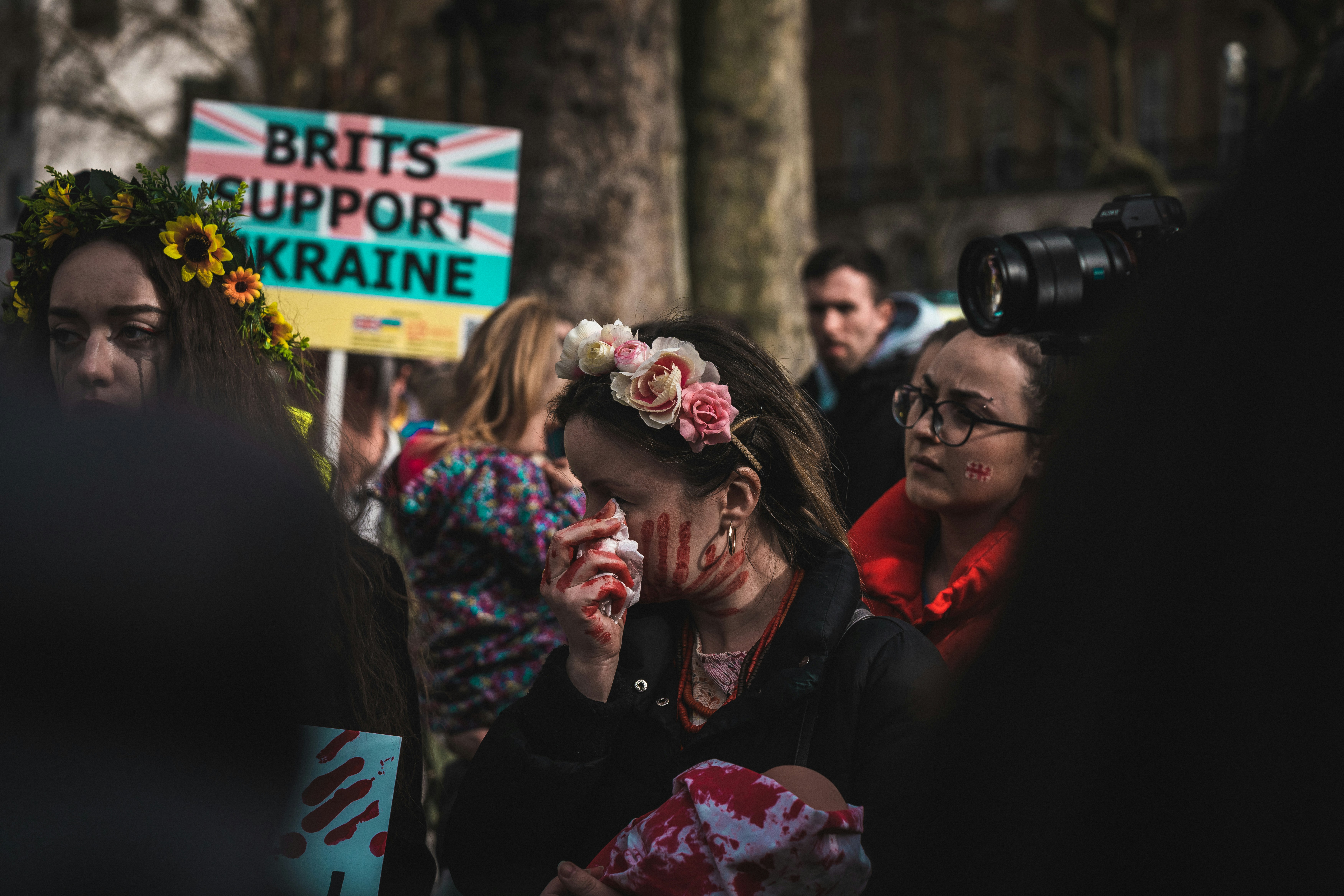 Floral Resistance: A Flower-Crowned Protester Amid a Pro-Ukraine Rally