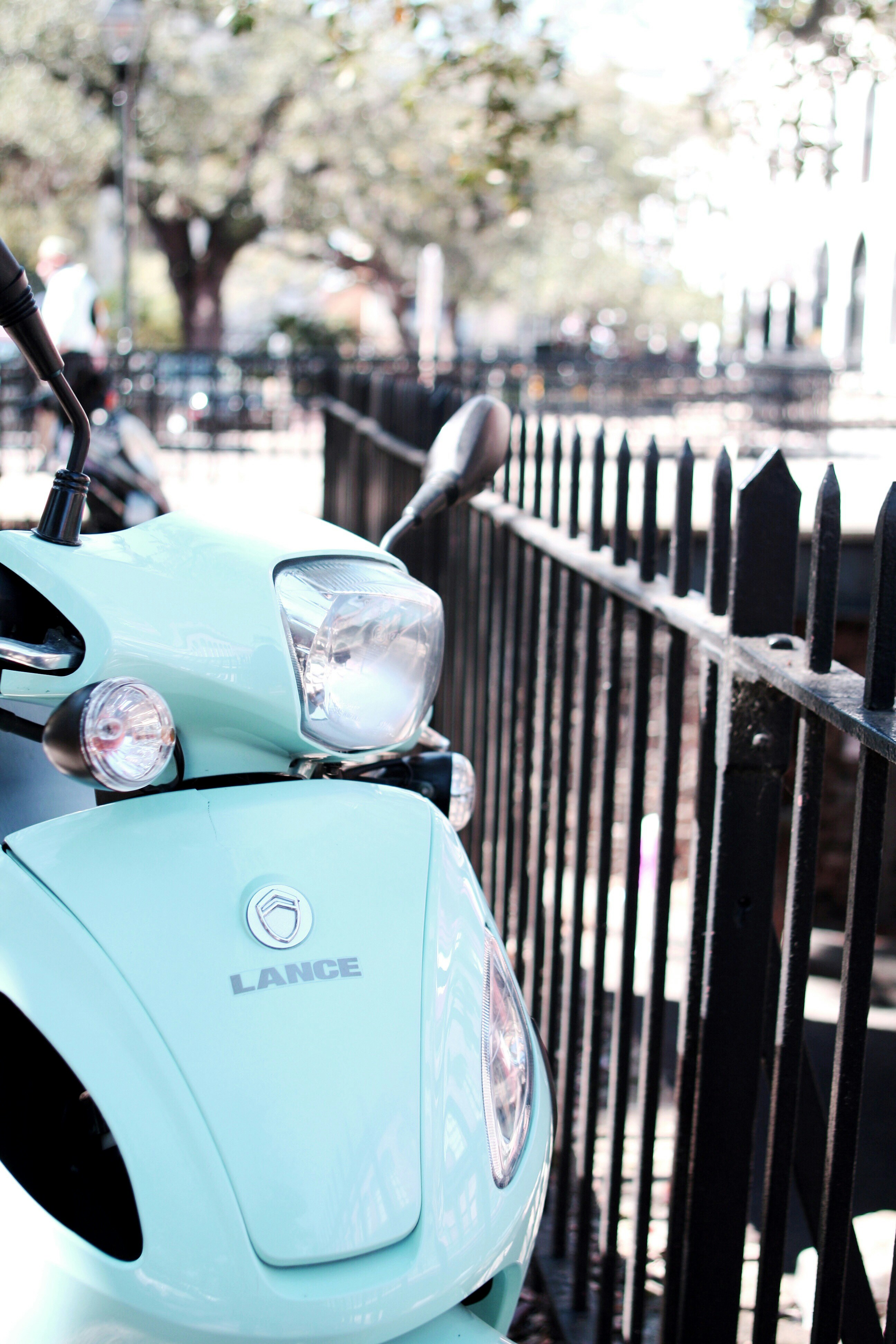 Pastel Sprint: a mint scooter beside a wrought-iron fence