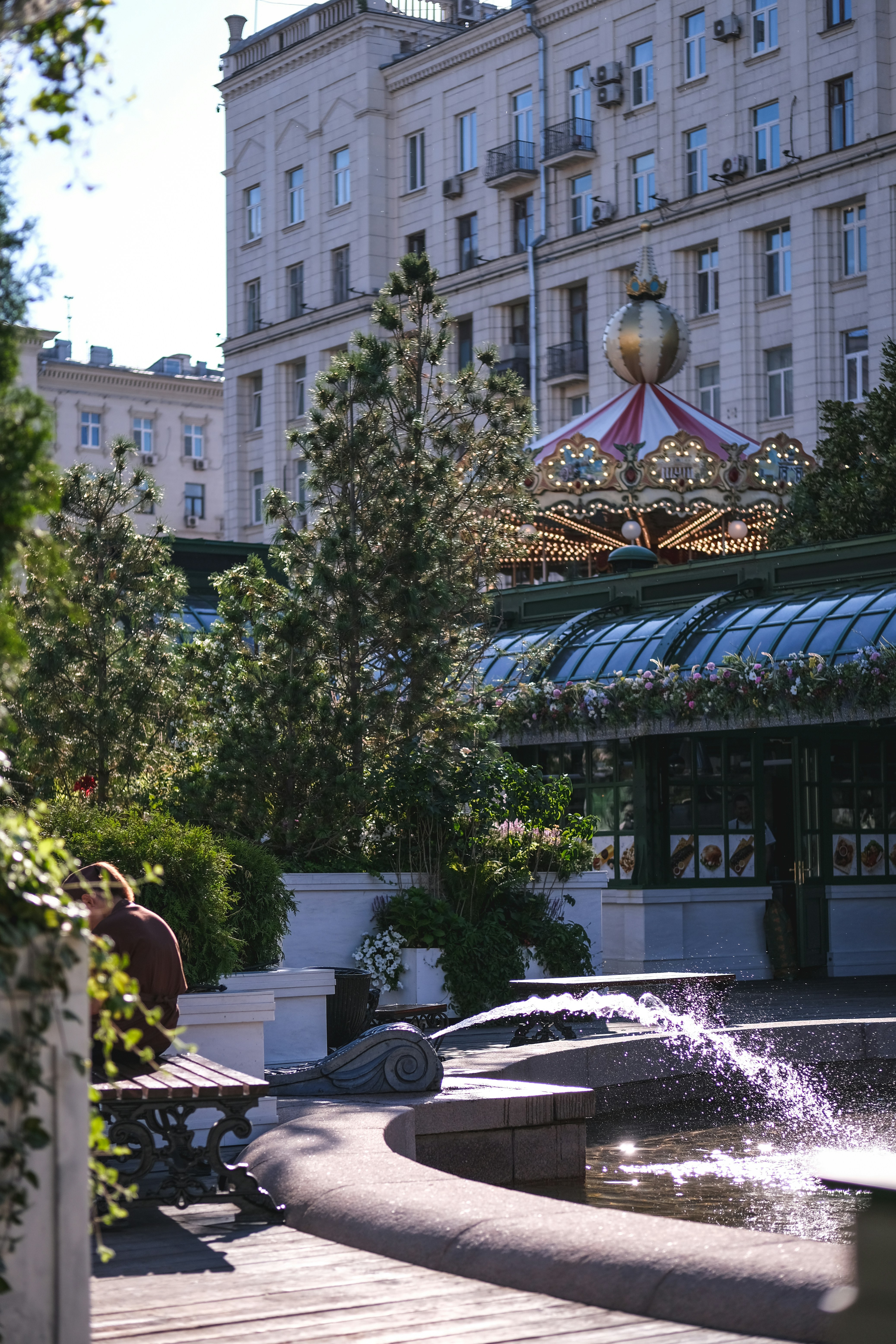 Carousel Luminaries Over a Tranquil Urban Fountain