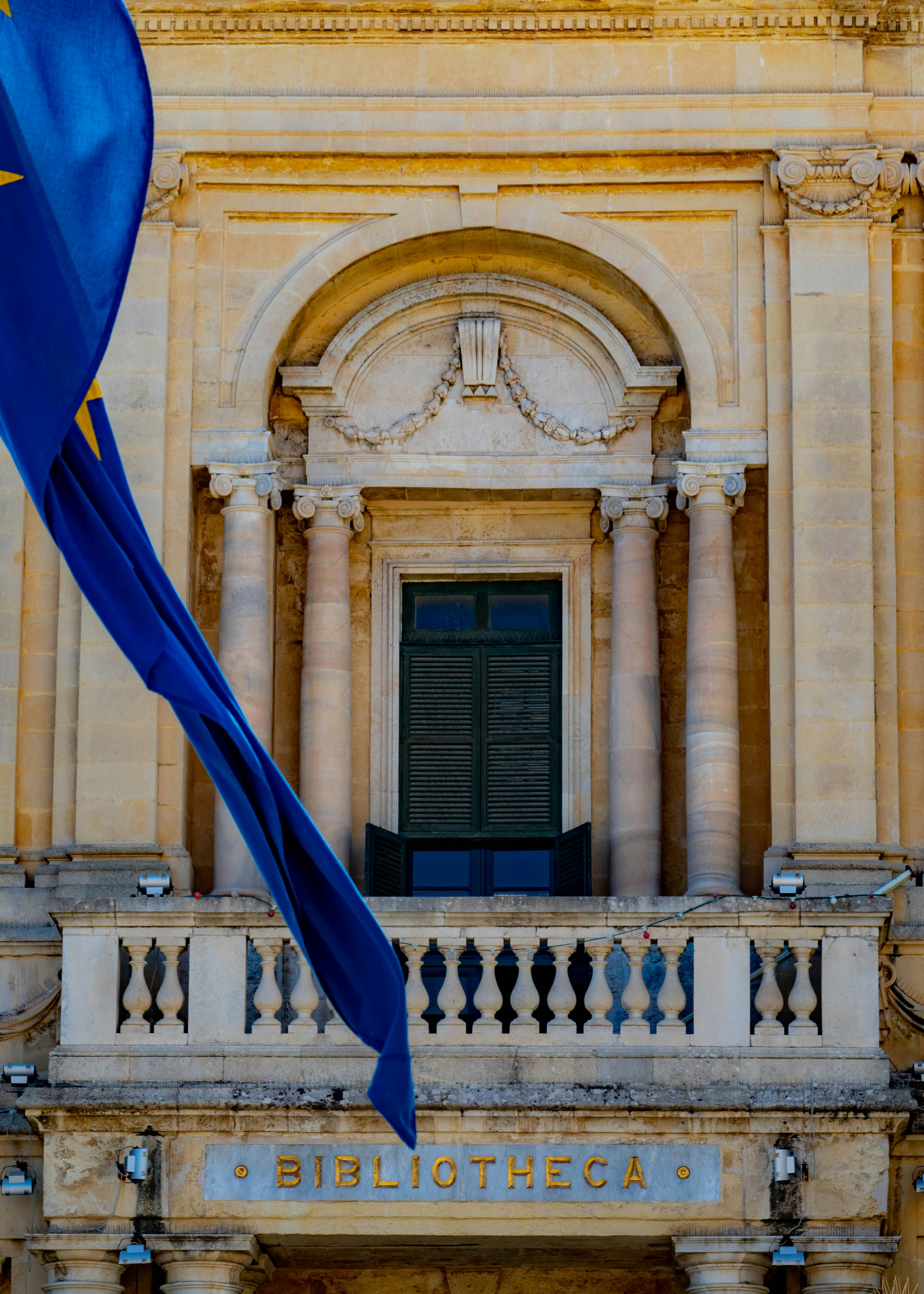 The Arch of Quiet Grandeur: Blue Drapes Frame the Bibliotheca Facade