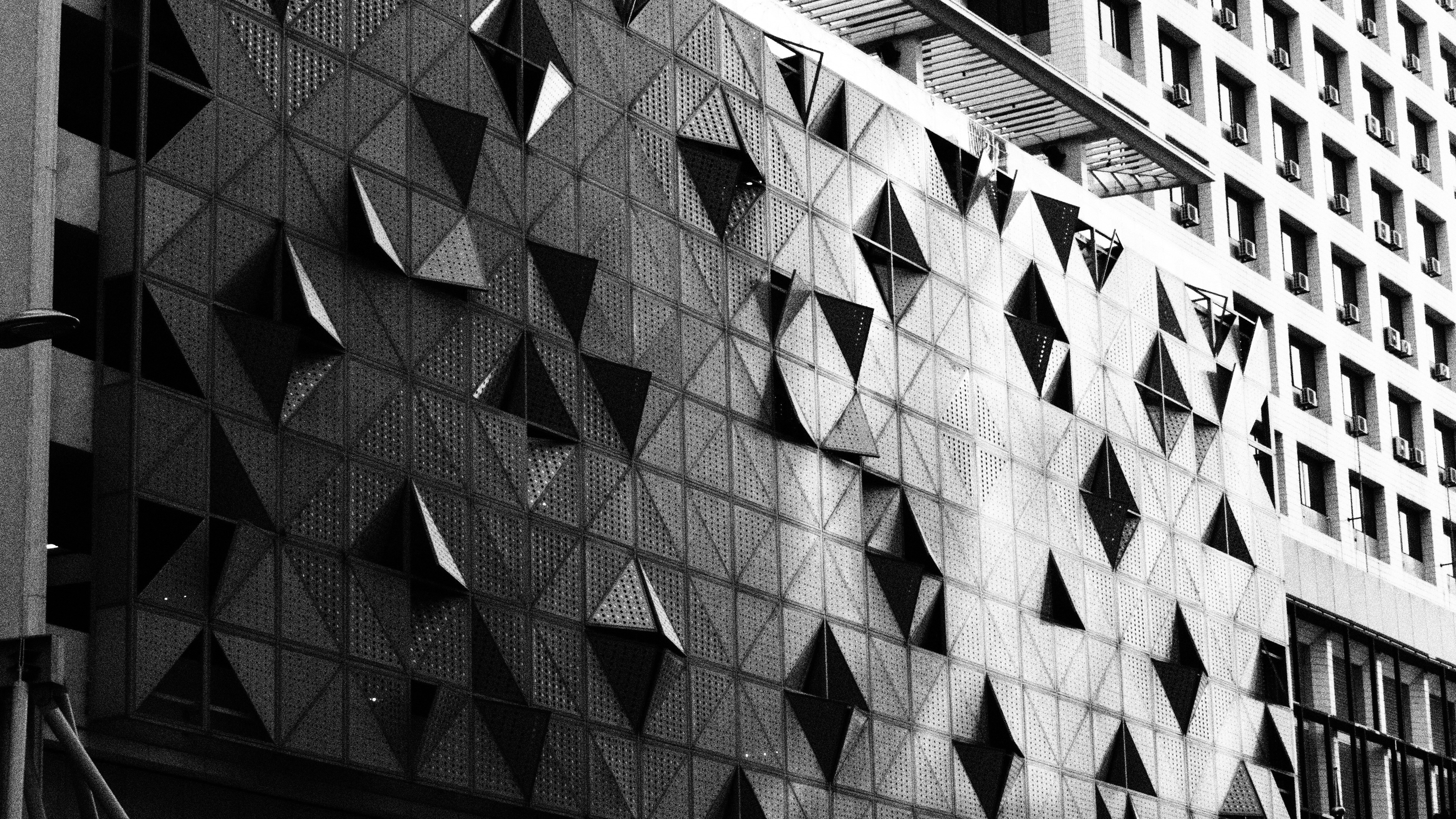 Modern building facade with intricate geometric patterns creating a dynamic visual texture.
