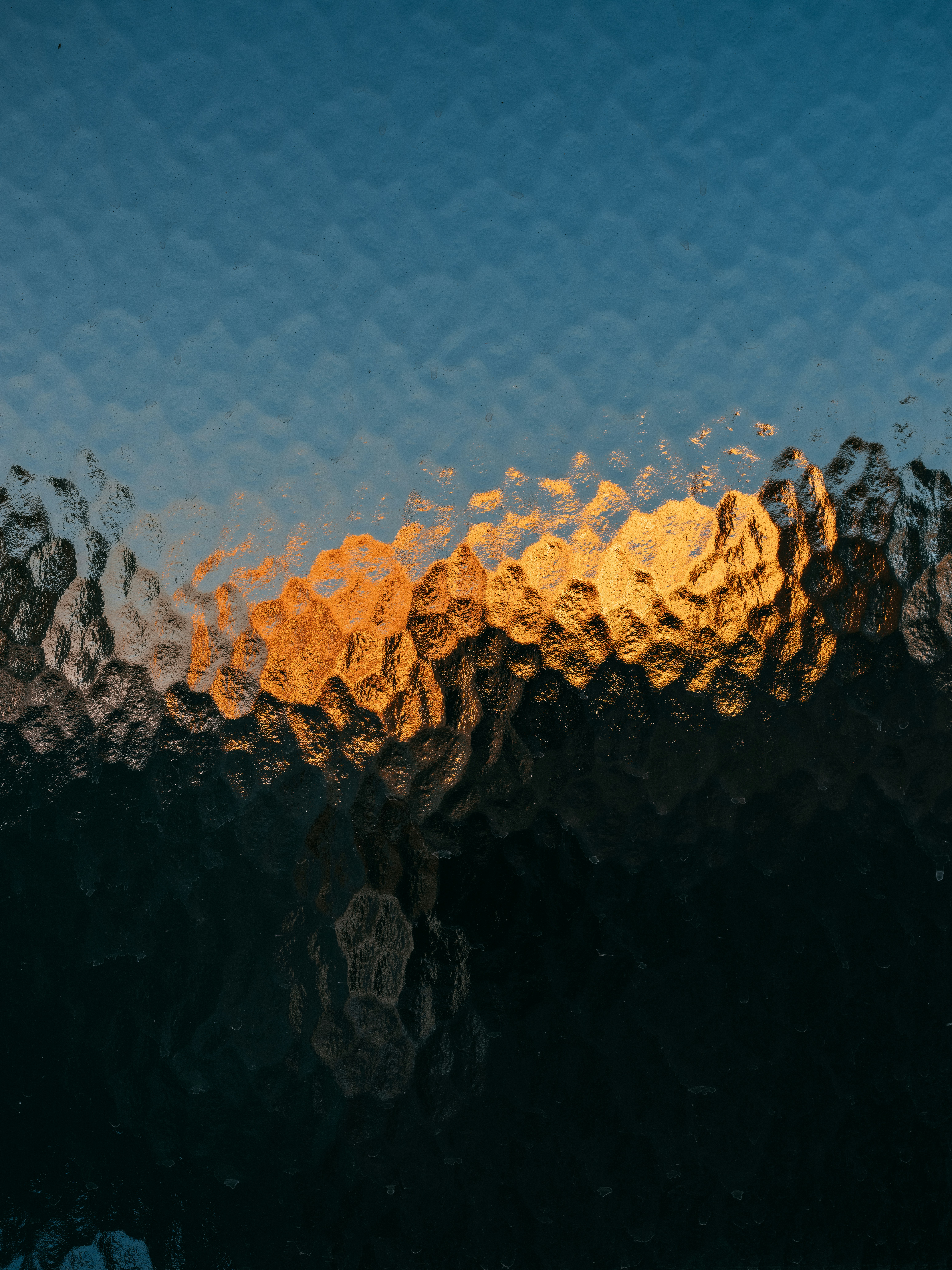 Sunset hues filtered through textured glass, creating a mesmerizing interplay of light and shadow.