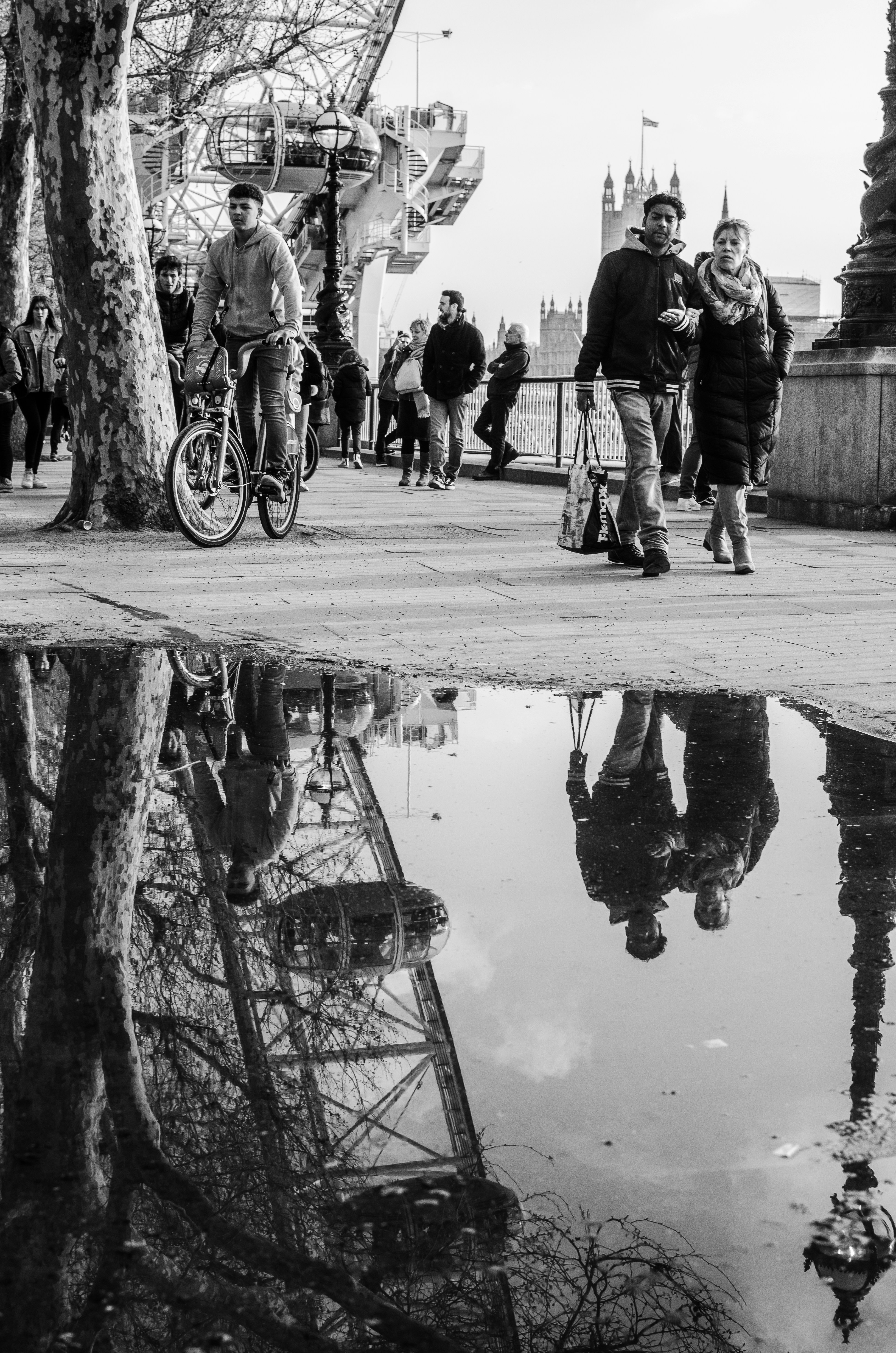 Thames Quiet: Pedestrians, a Cyclist, and a Wet Mirror
