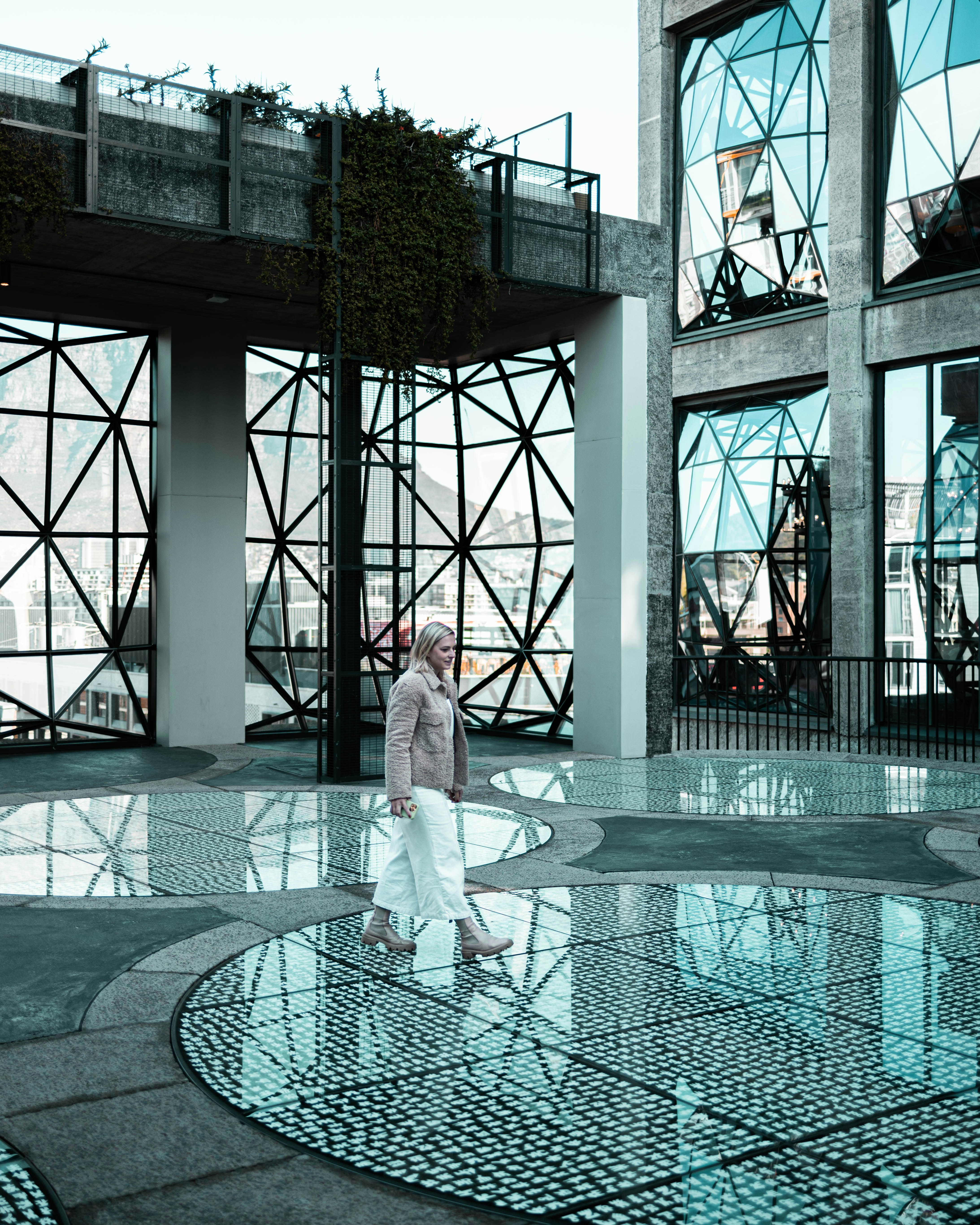 Urban Glass and Gray: A lone traveler in a geometric atrium