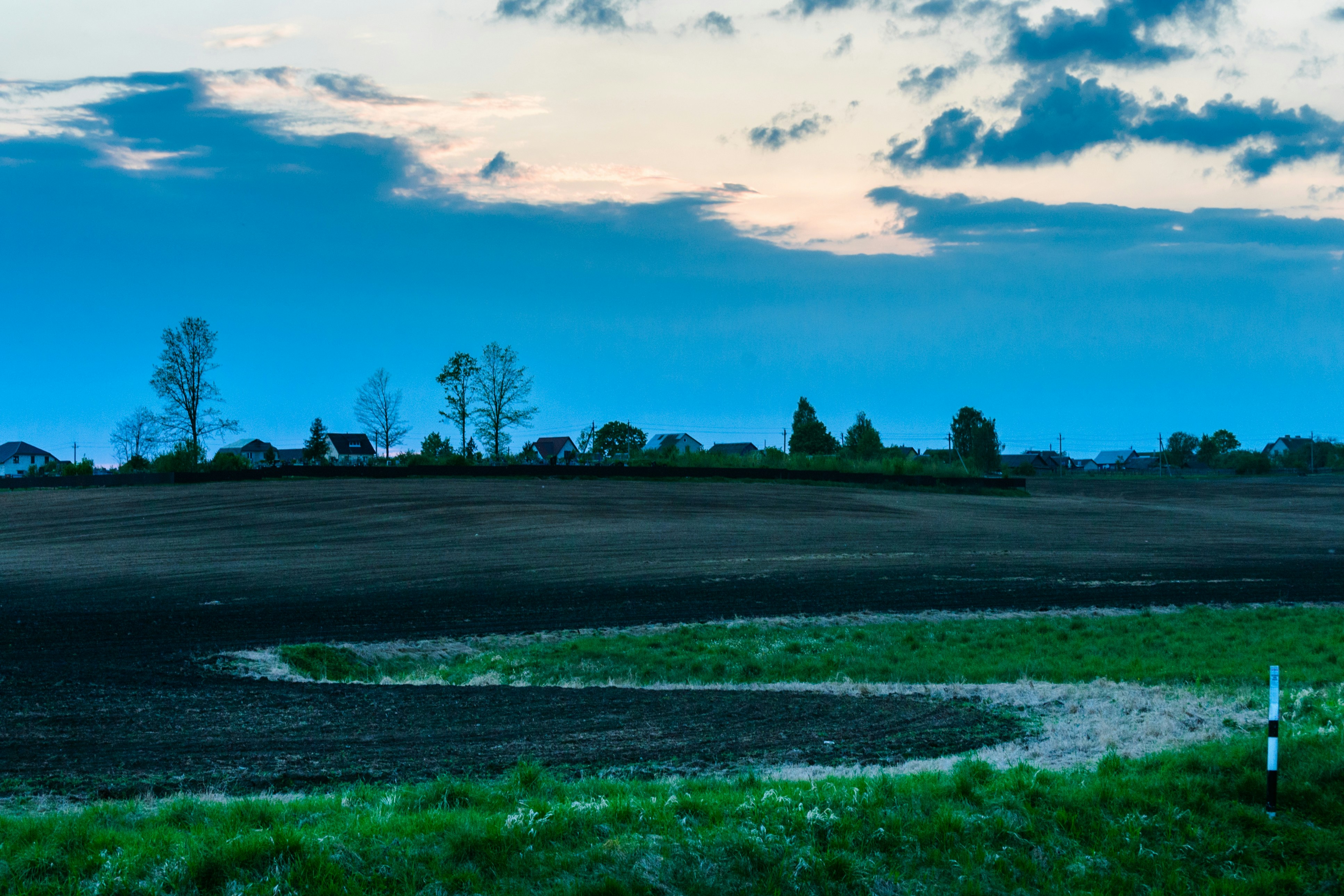 A large field with a puddle of water in it photo – Free Blue Image on ...