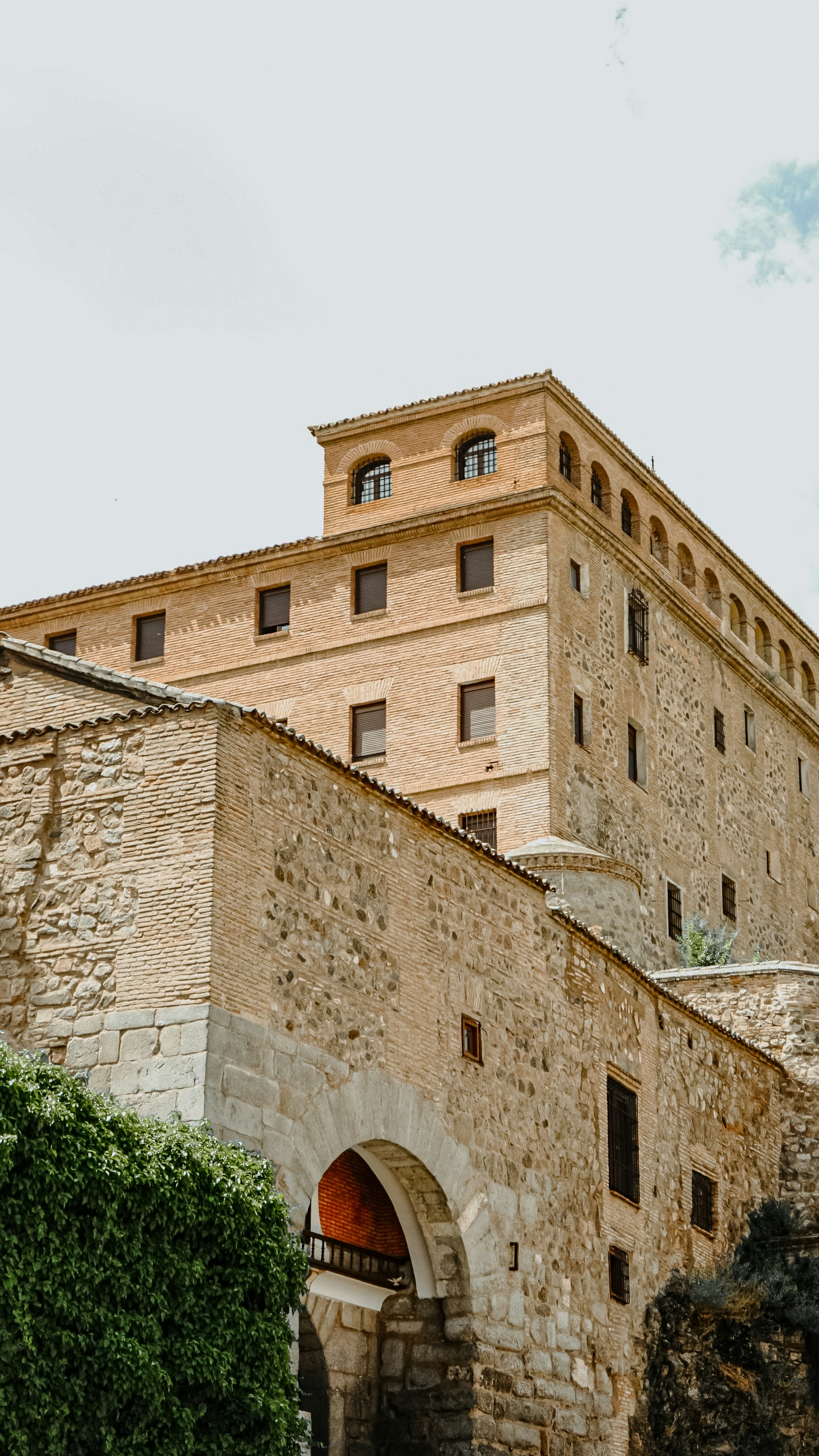 Ancient stone building with a blend of brick and natural elements, showcasing architectural heritage against a clear sky.