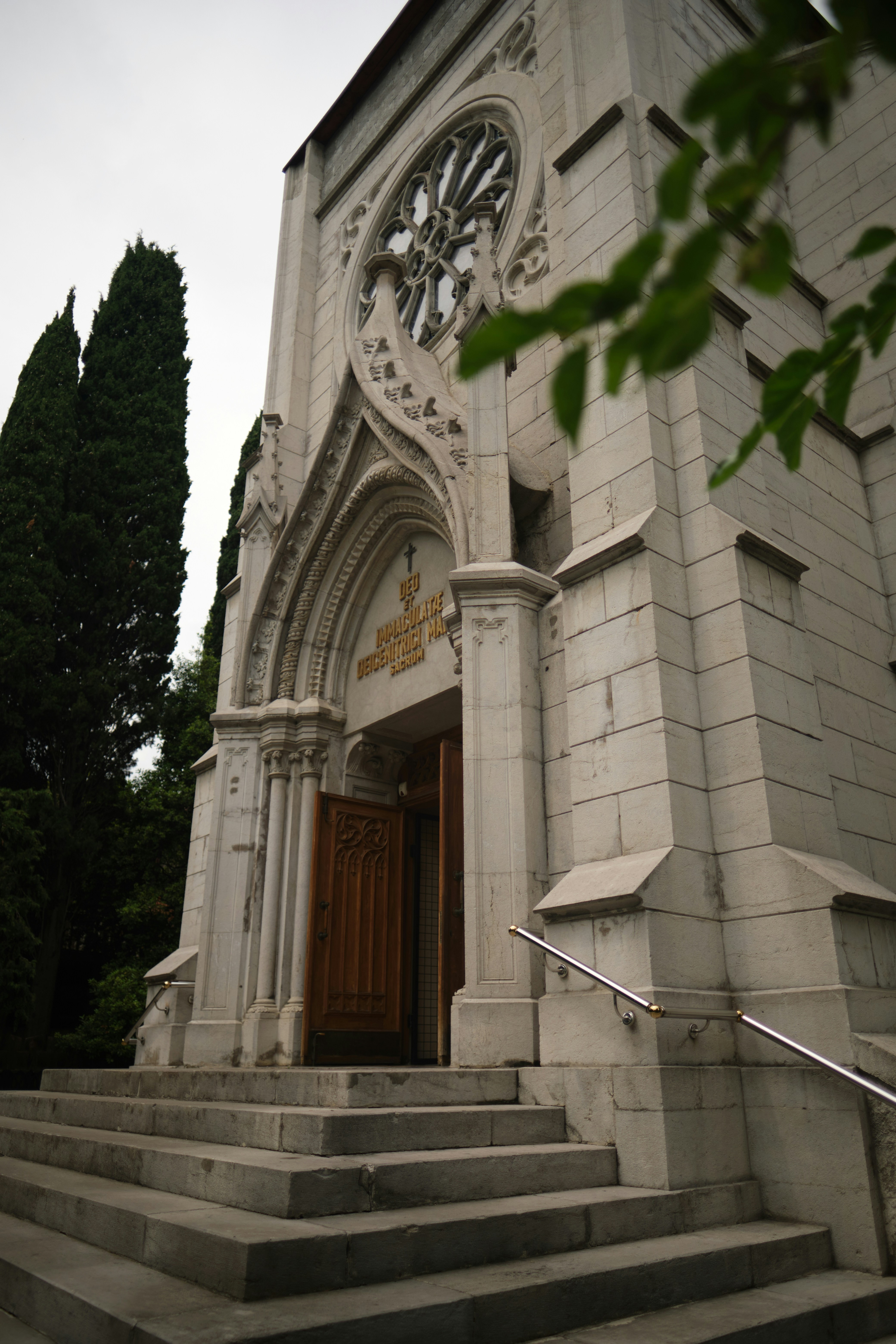 Stone Archway Cathedral Entrance Framed by Greenery and Weathered Masonry