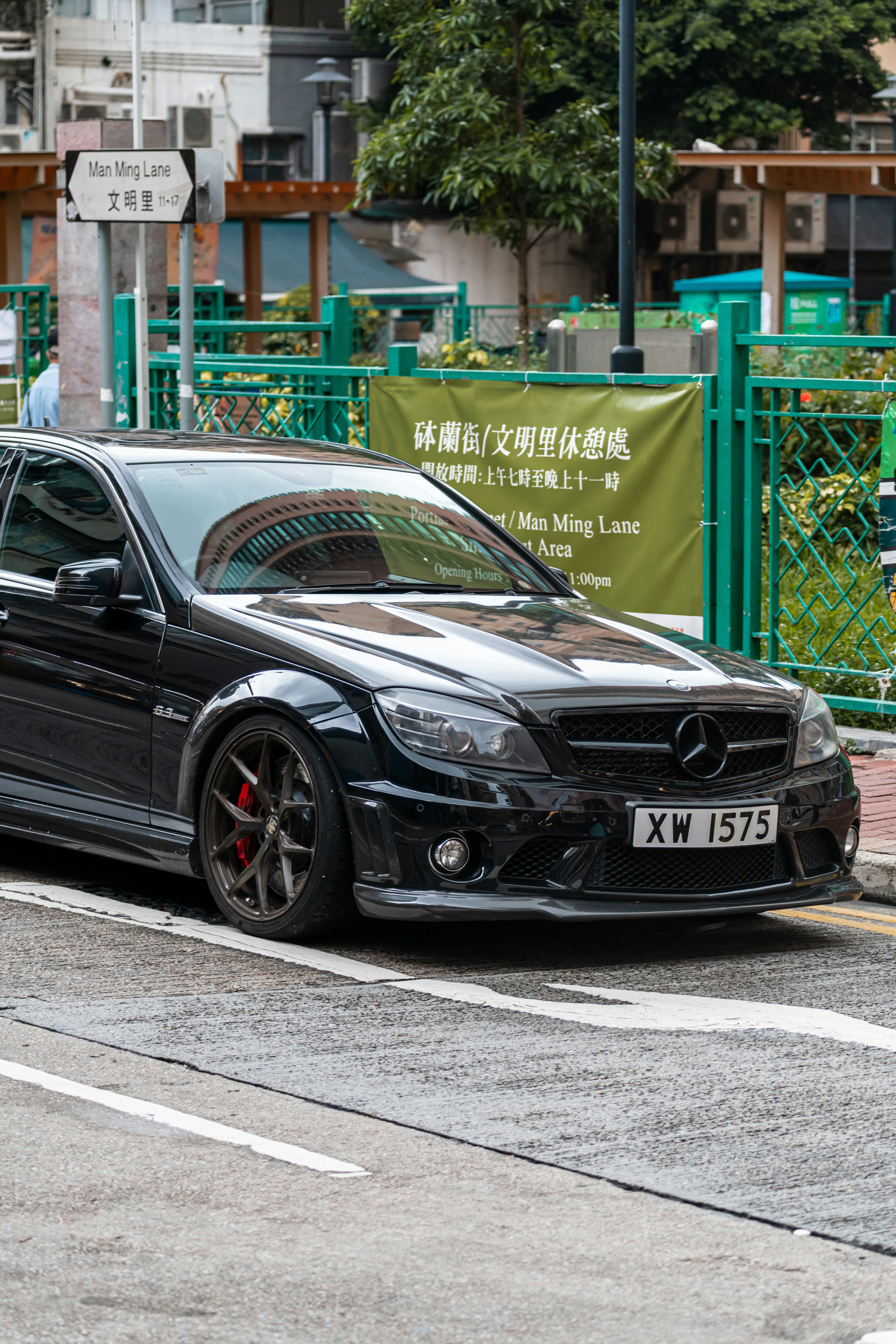 Black Mercedes GT on a City Street with Construction Fence backdrop