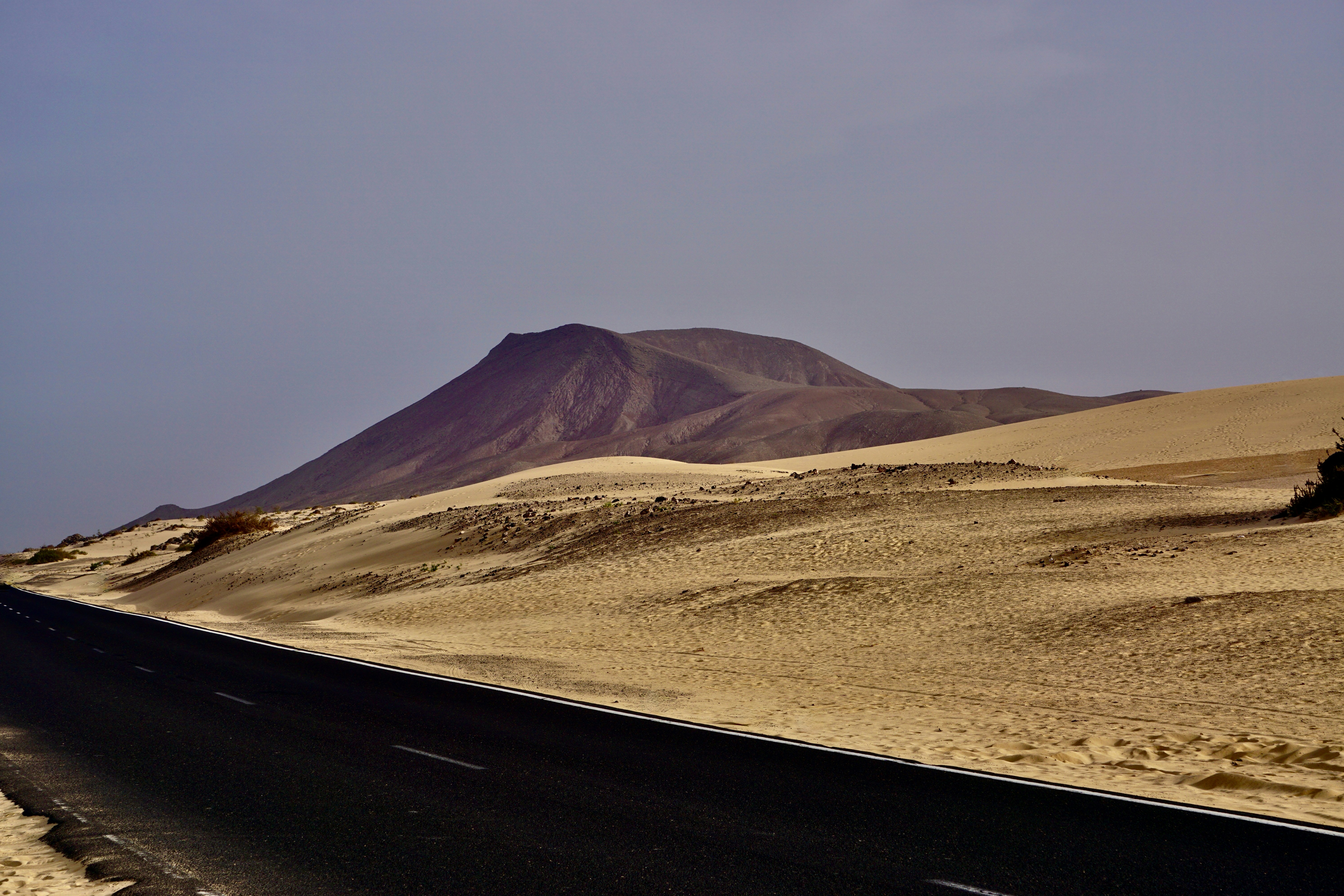 Horizon Highway: Desert Road Toward a Dune-Topped Peak