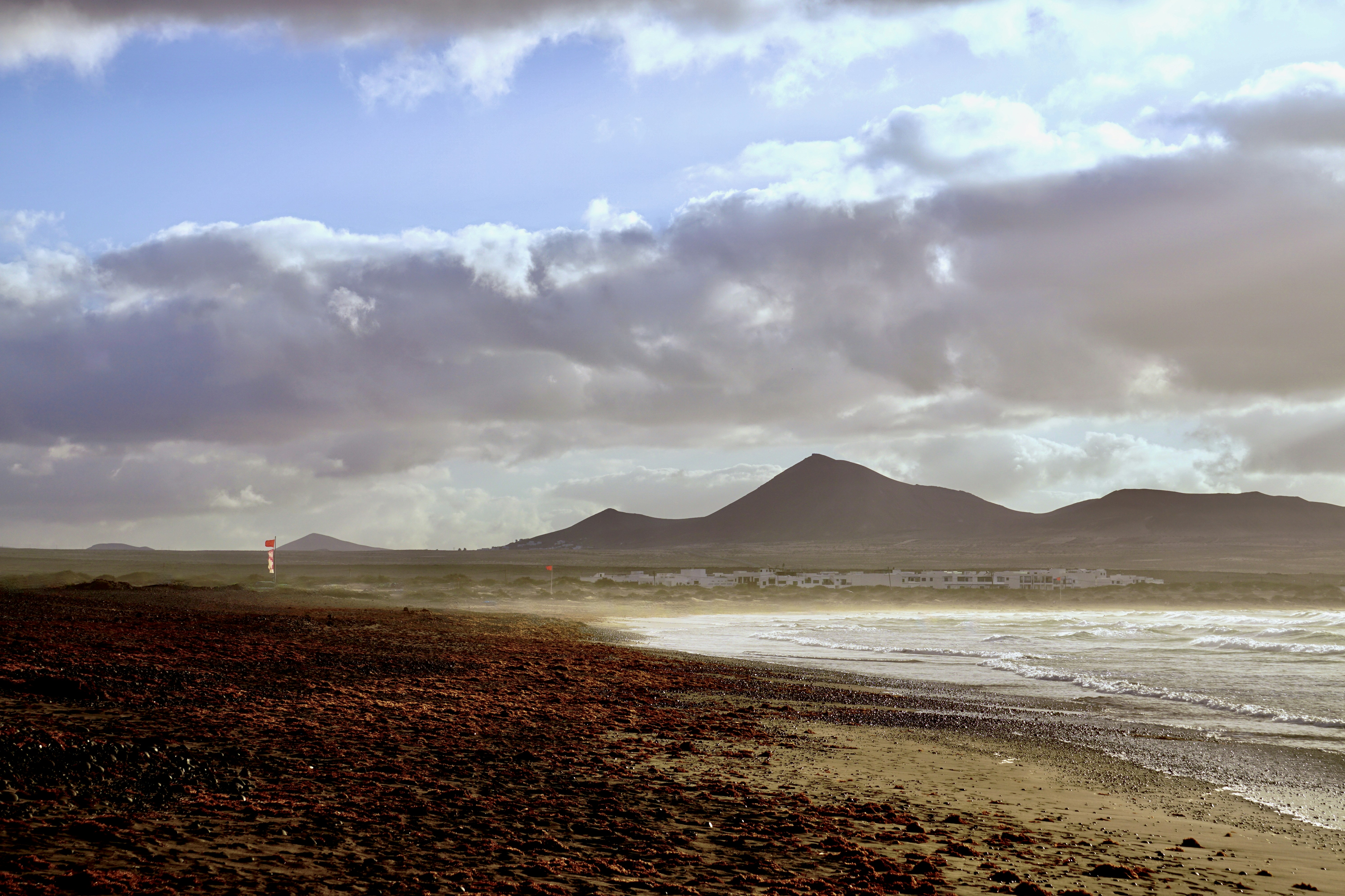 Beacon at the Edge: A Windswept Shore Beneath Layered Clouds