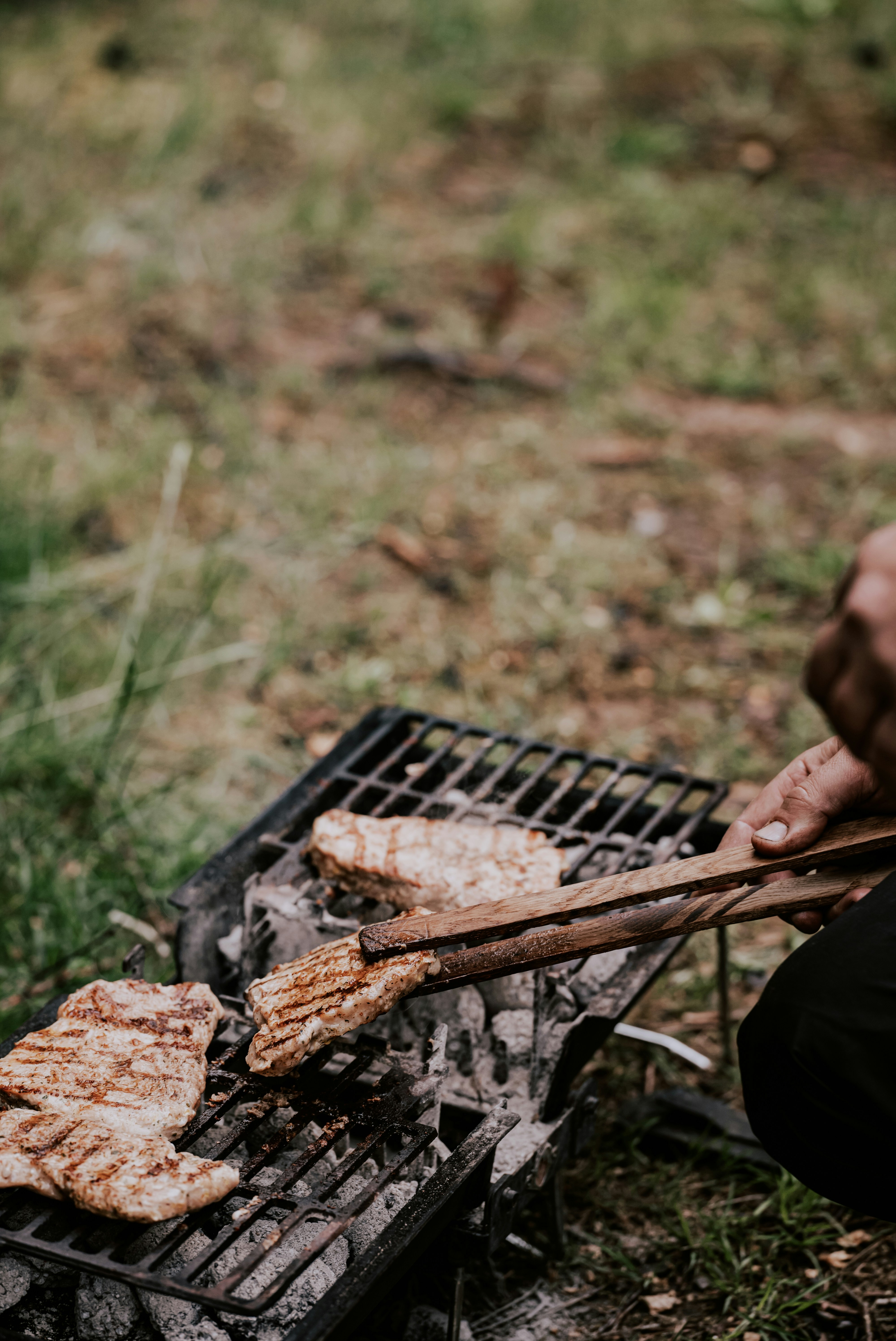 Foto Una persona asando carne en una parrilla – Imagen Gris gratis en ...