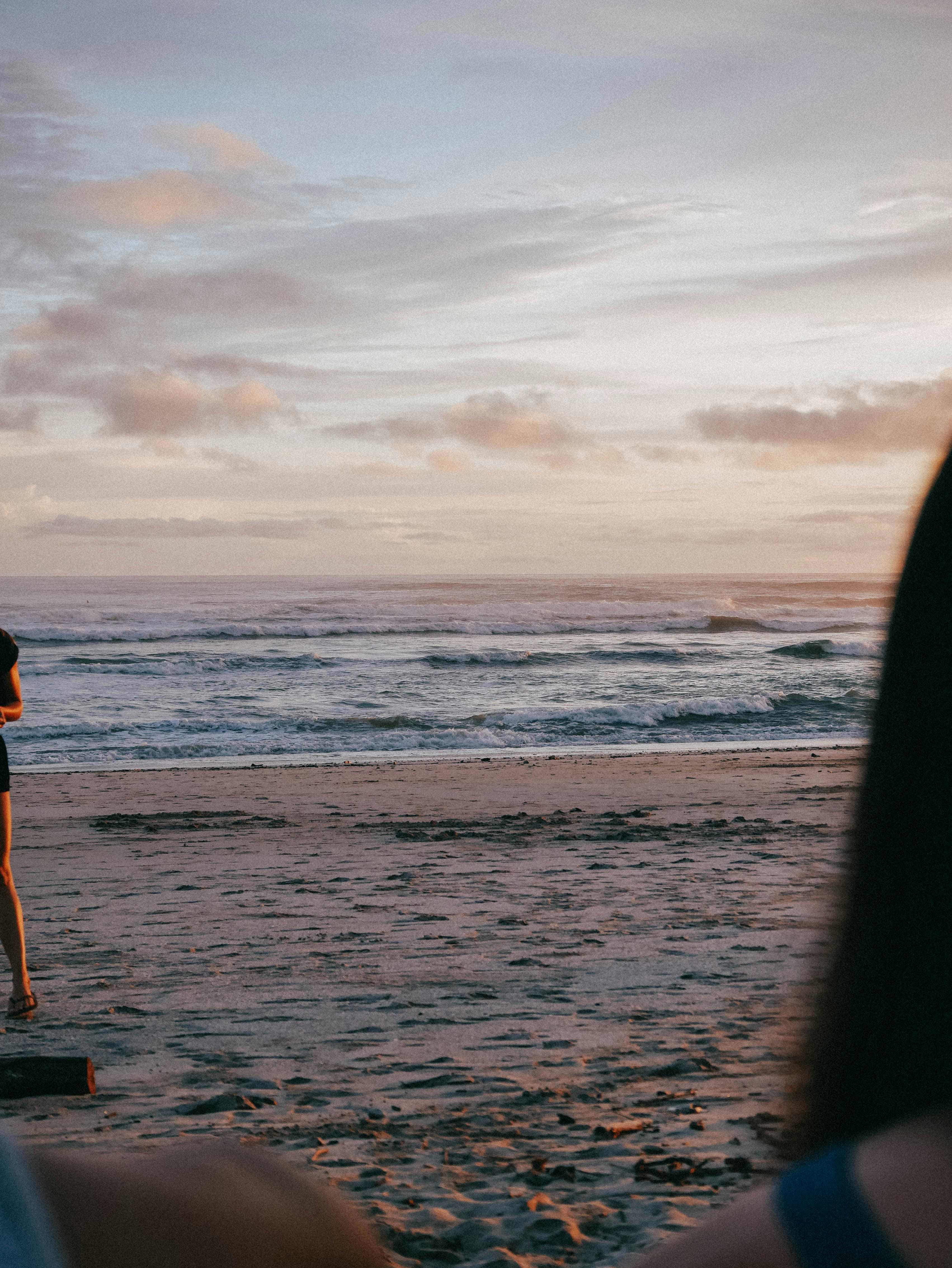 Golden Hour on the Edge: A Beach Scene Framed by Silhouettes